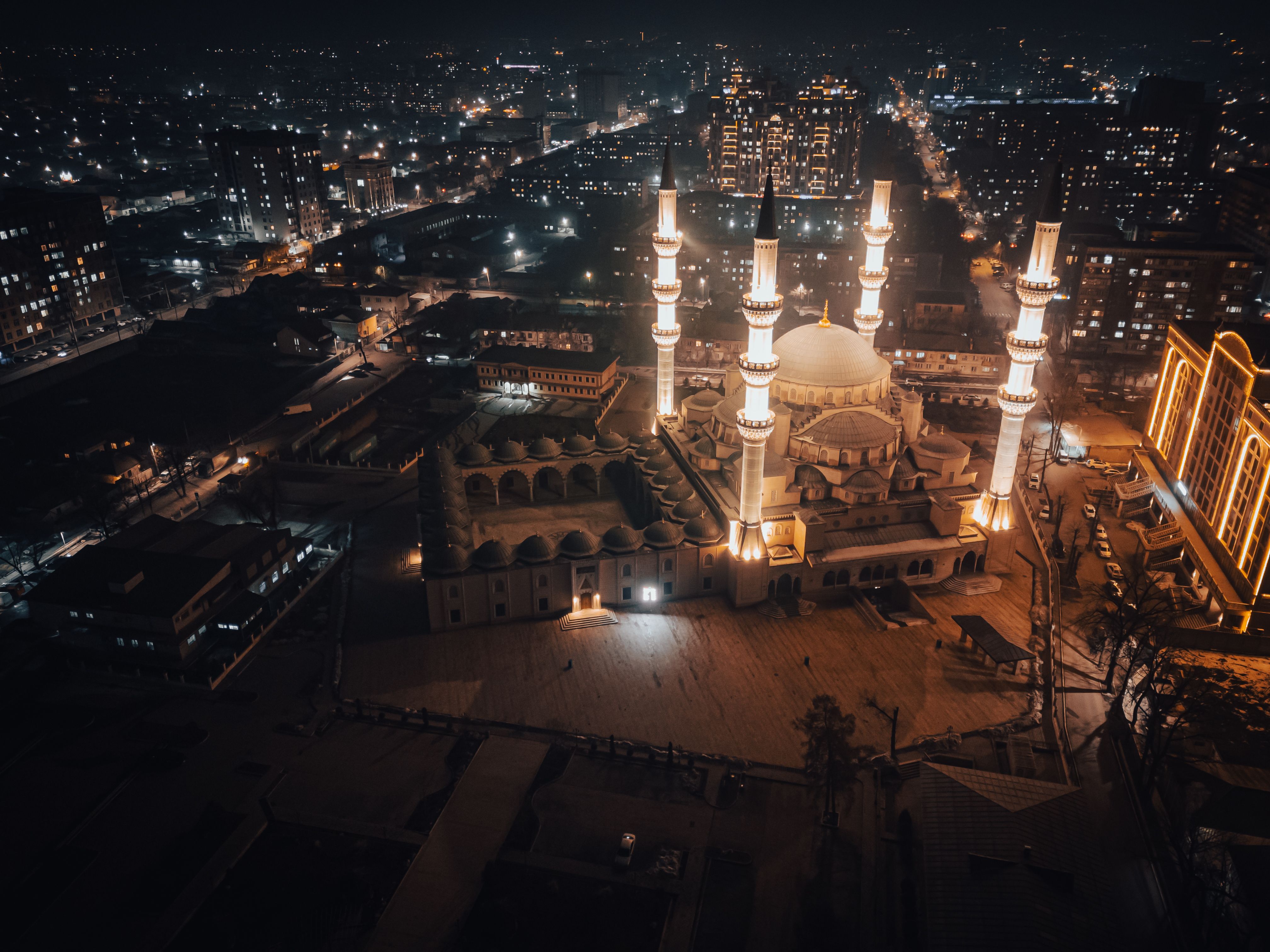 Night view of the illuminated Mosque with surrounding city lights ...