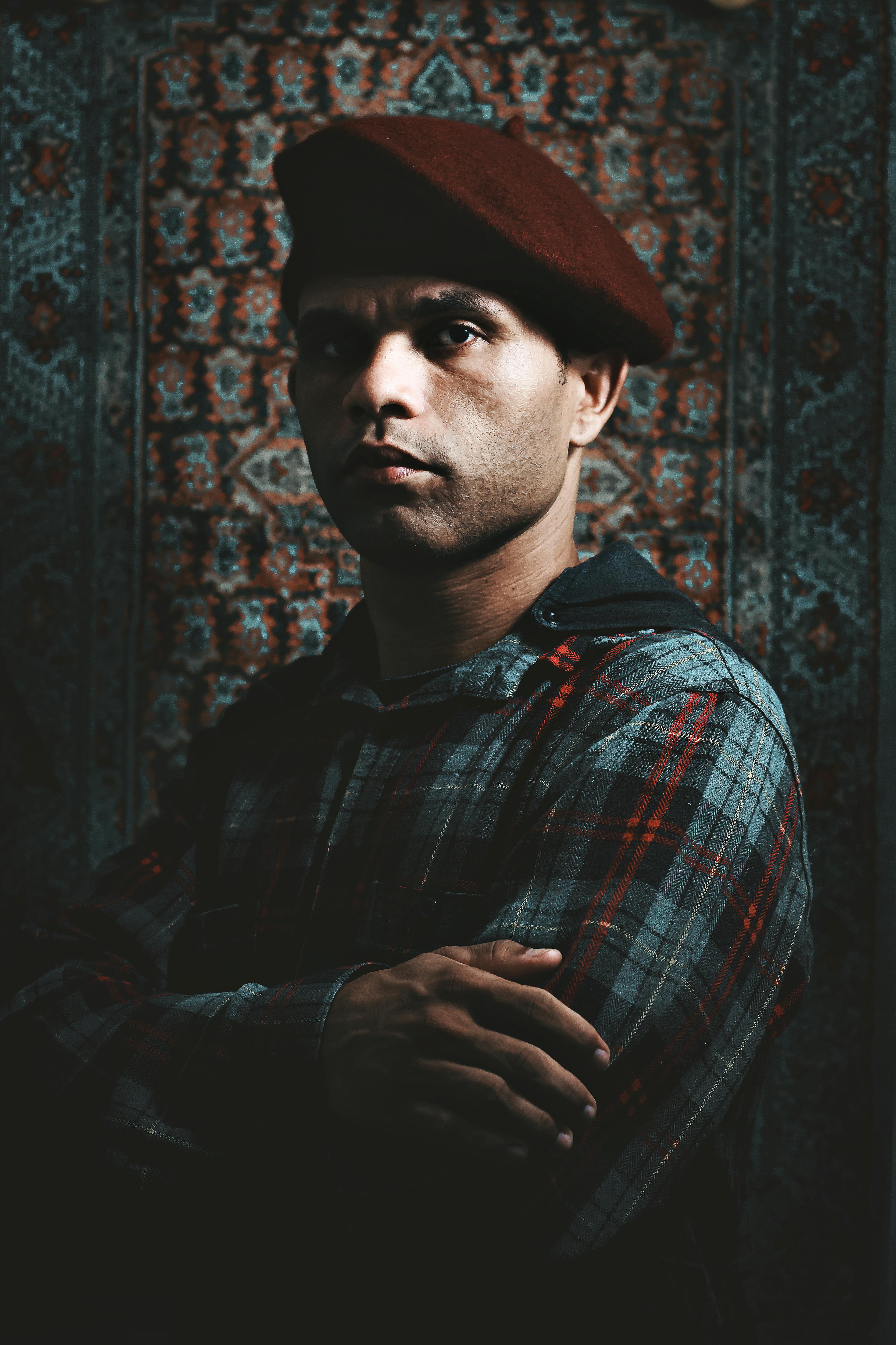 Ethnic man with beret standing in dark place · Free Stock Photo