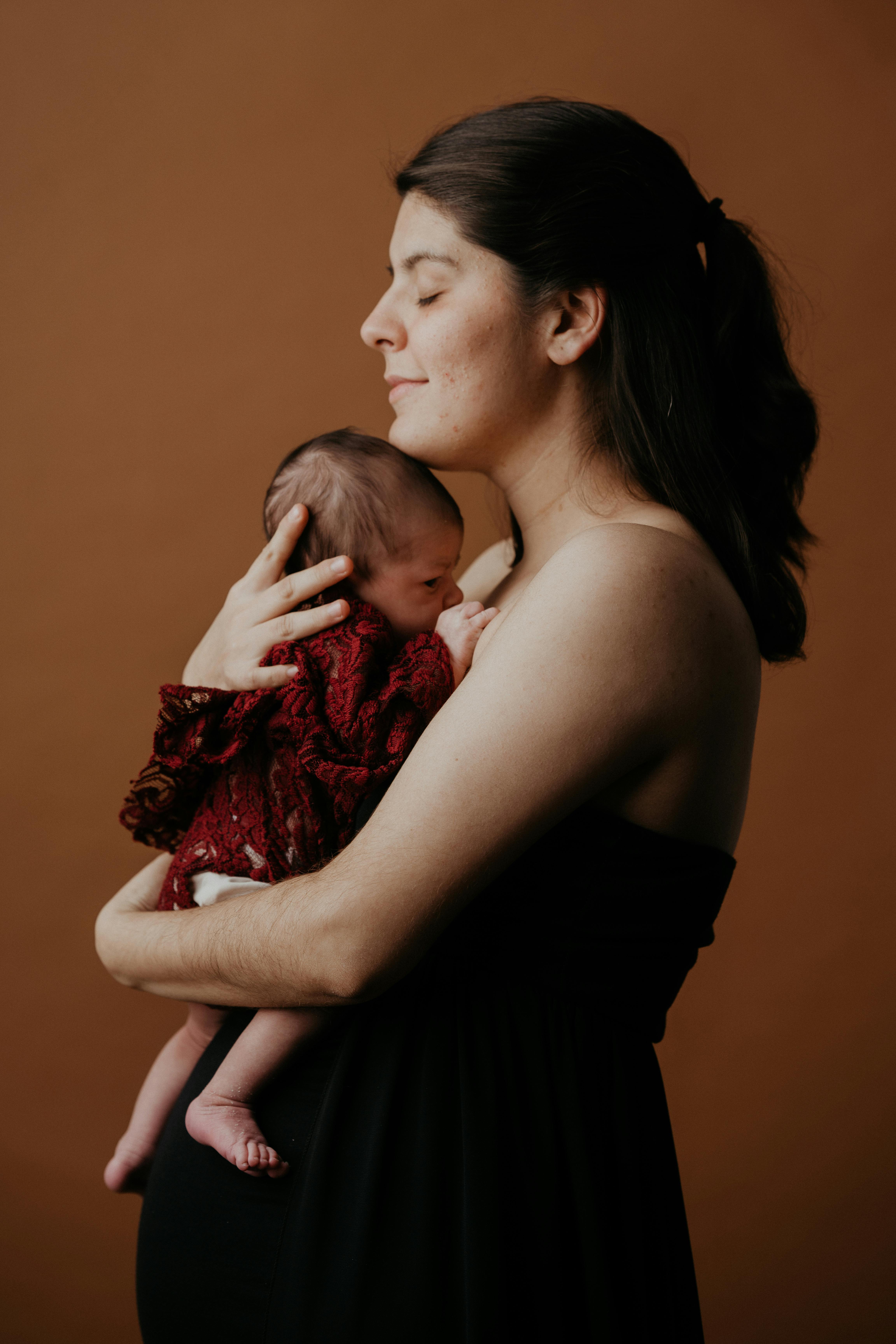 Studio Shot of a Woman Holding Her Newborn Baby · Free Stock Photo