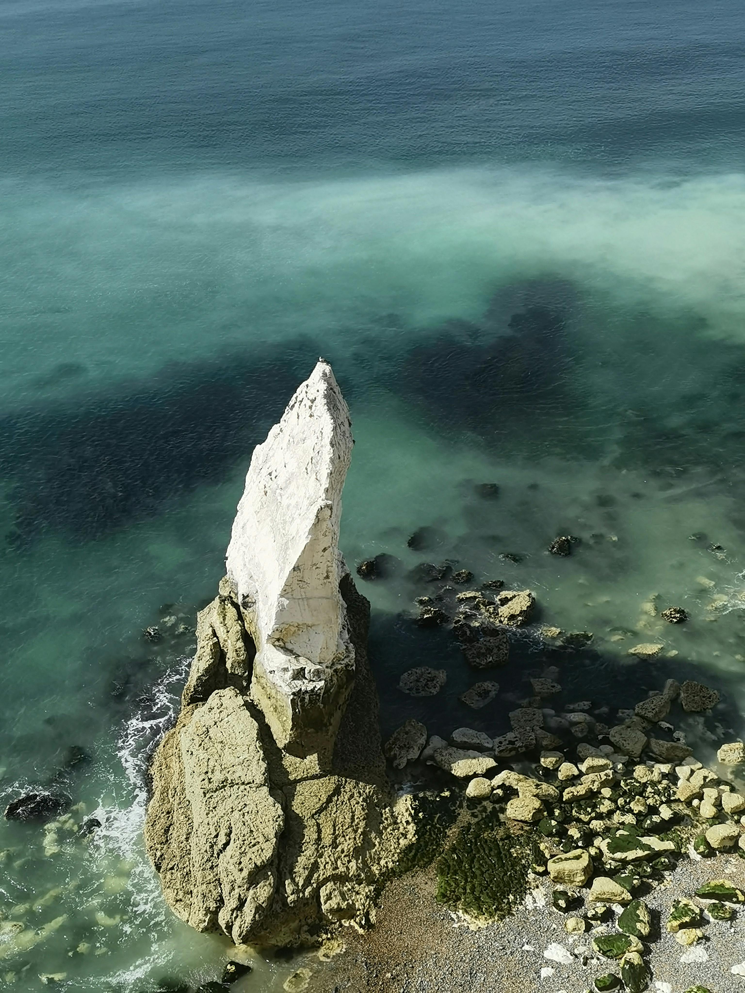 White Rock Formation on Rocky Beach with Turquoise Water · Free Stock Photo