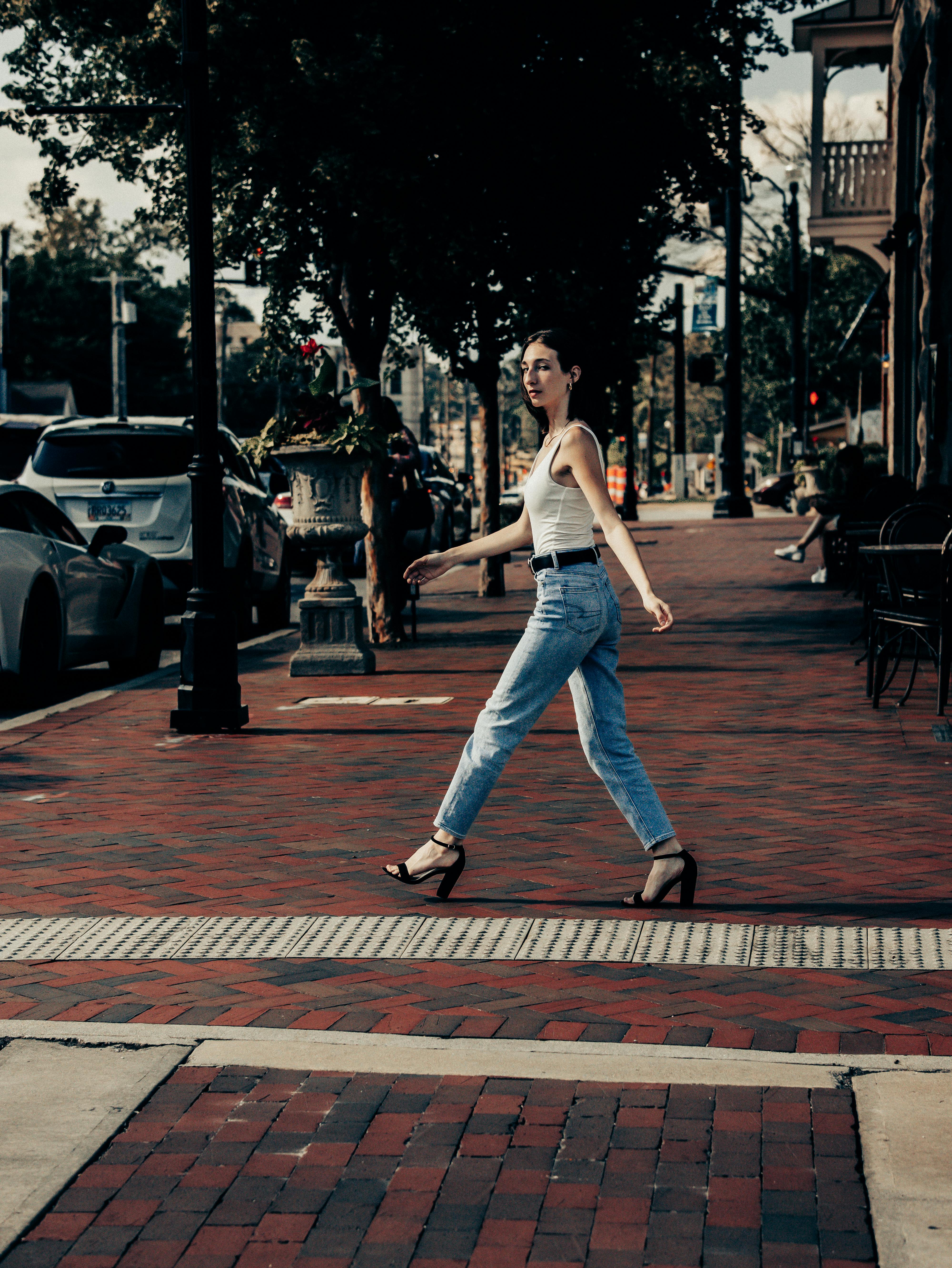Woman wearing denim jeans walking in the street · Free Stock Photo