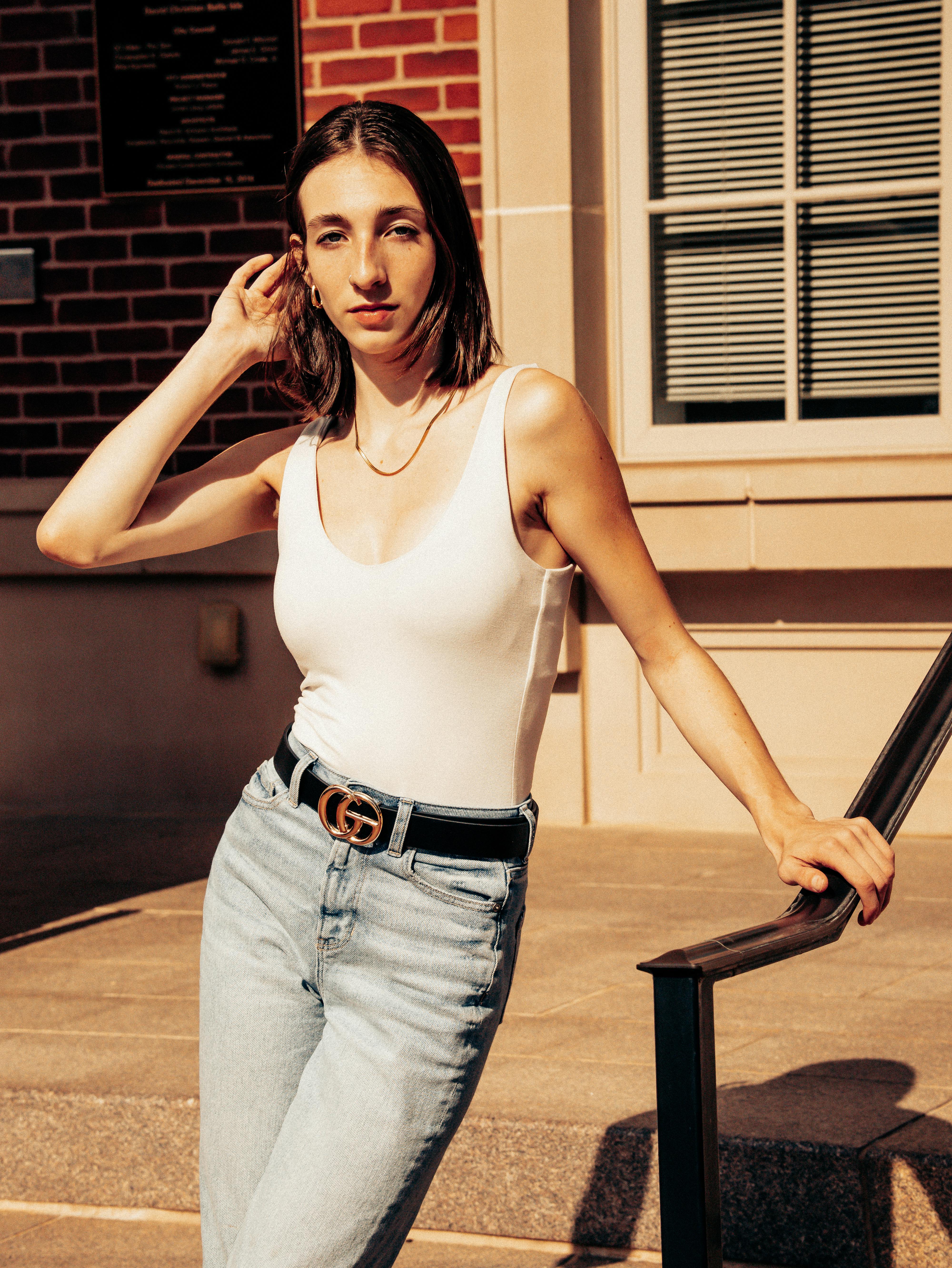 A woman in jeans and a white top is posing for a photo · Free Stock Photo