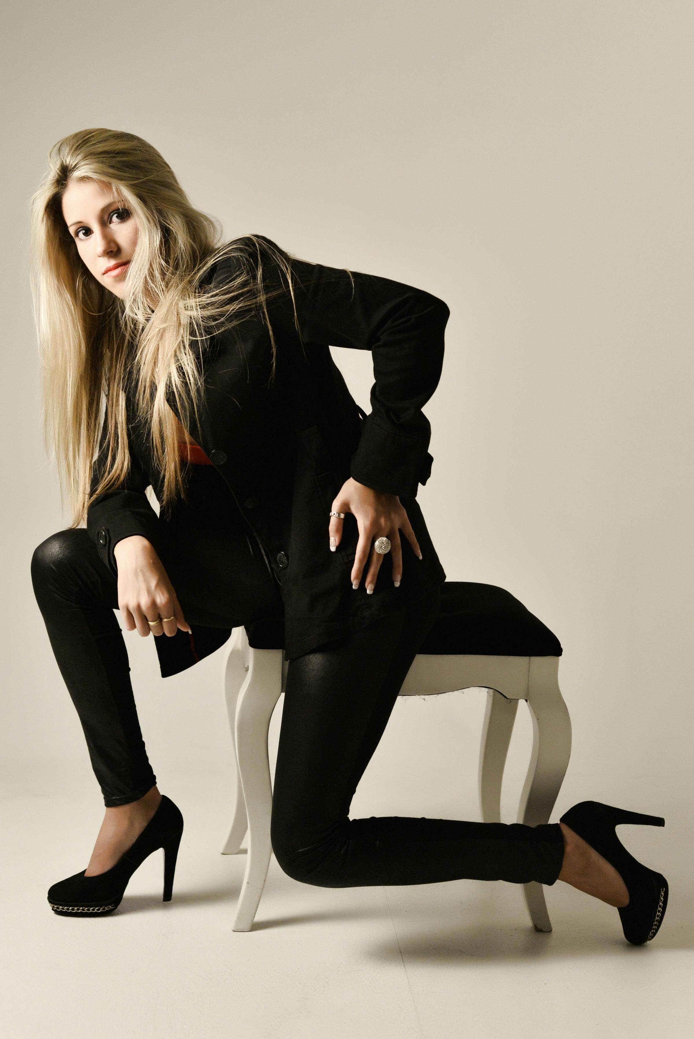 A woman in black leather pants and high heels sitting on a stool · Free ...