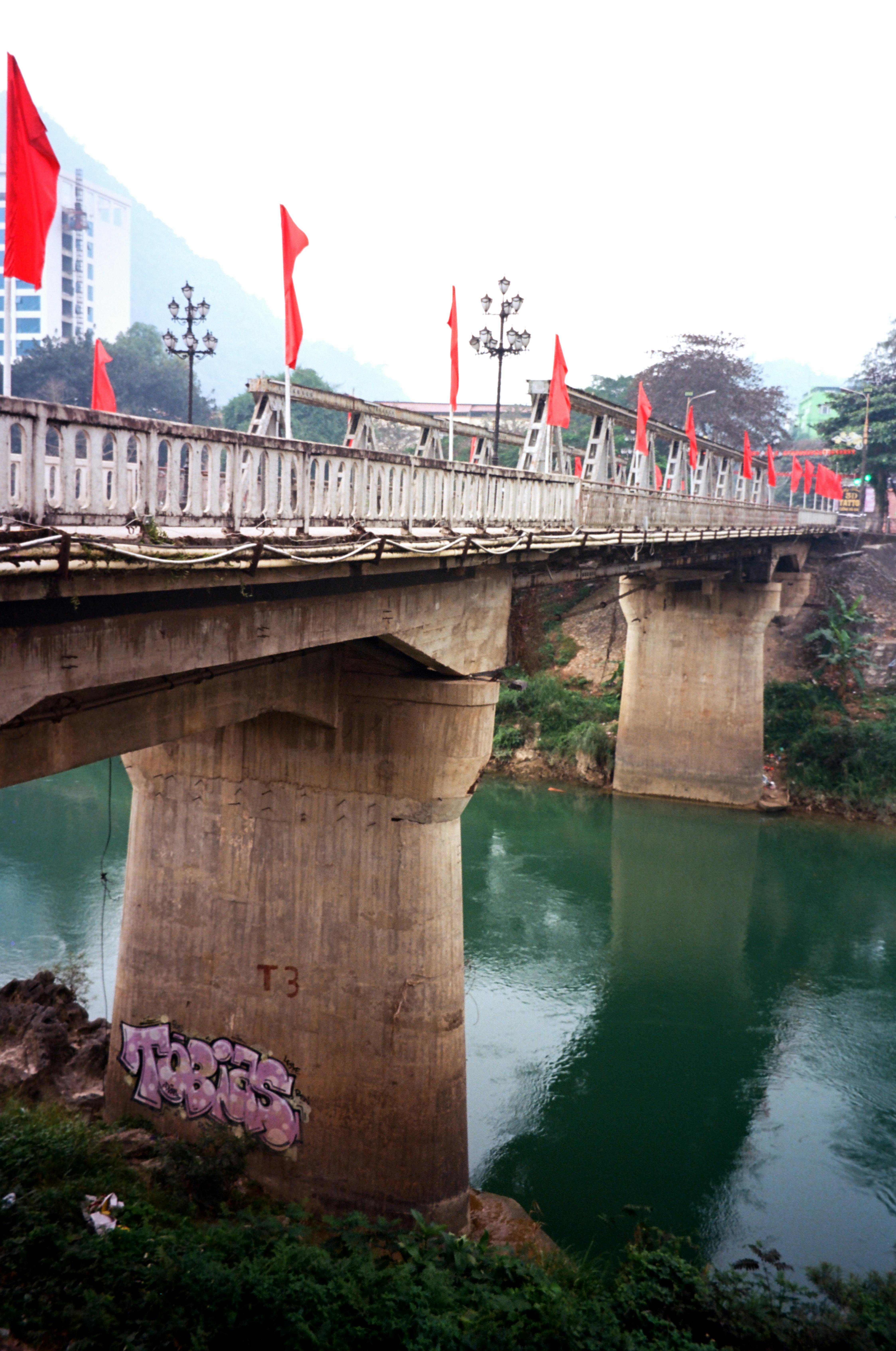 Row of Red Flags on a Bridge · Free Stock Photo