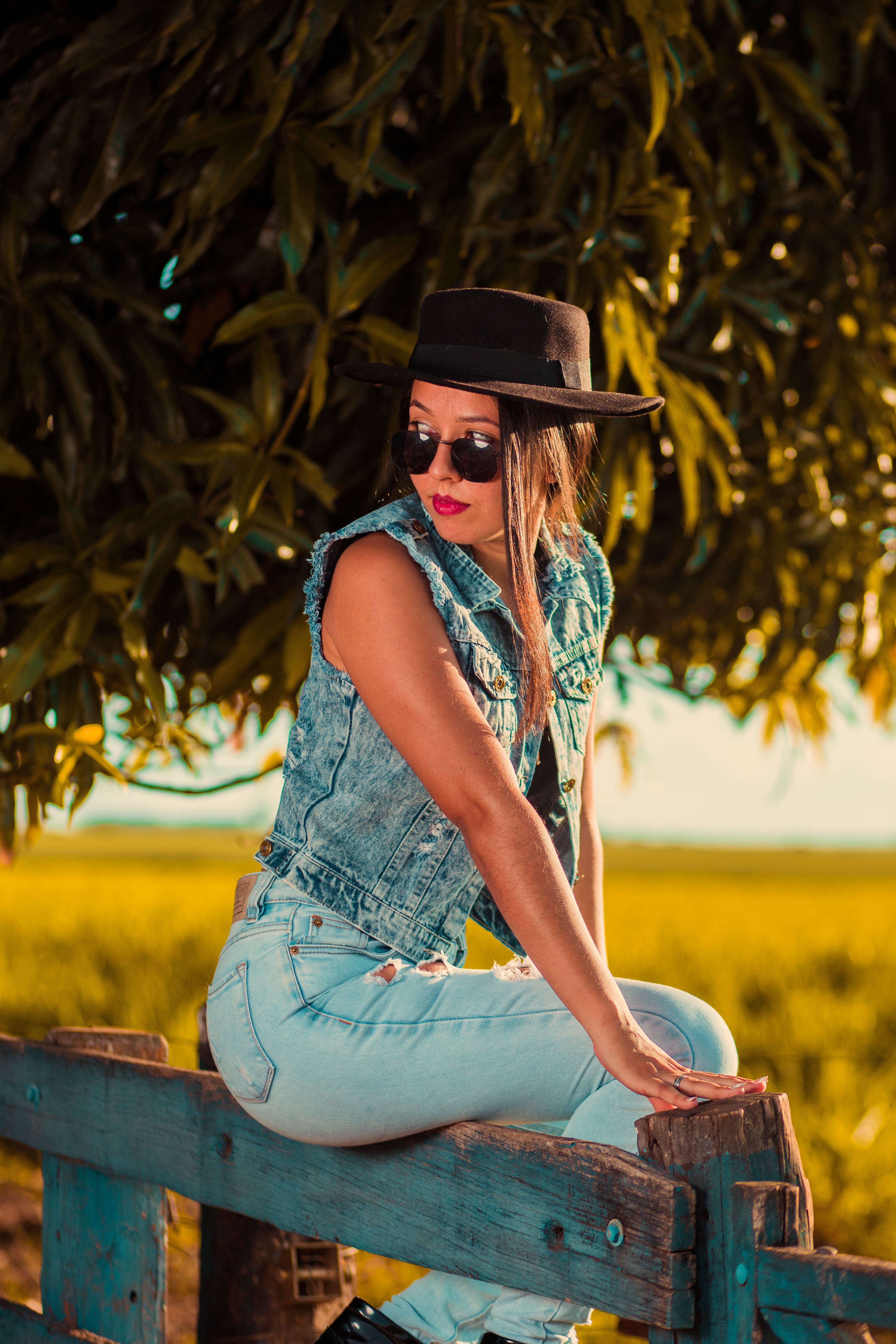 Female Model Wearing a Cowboy Hat and a Denim Waistcoat Sitting on a ...