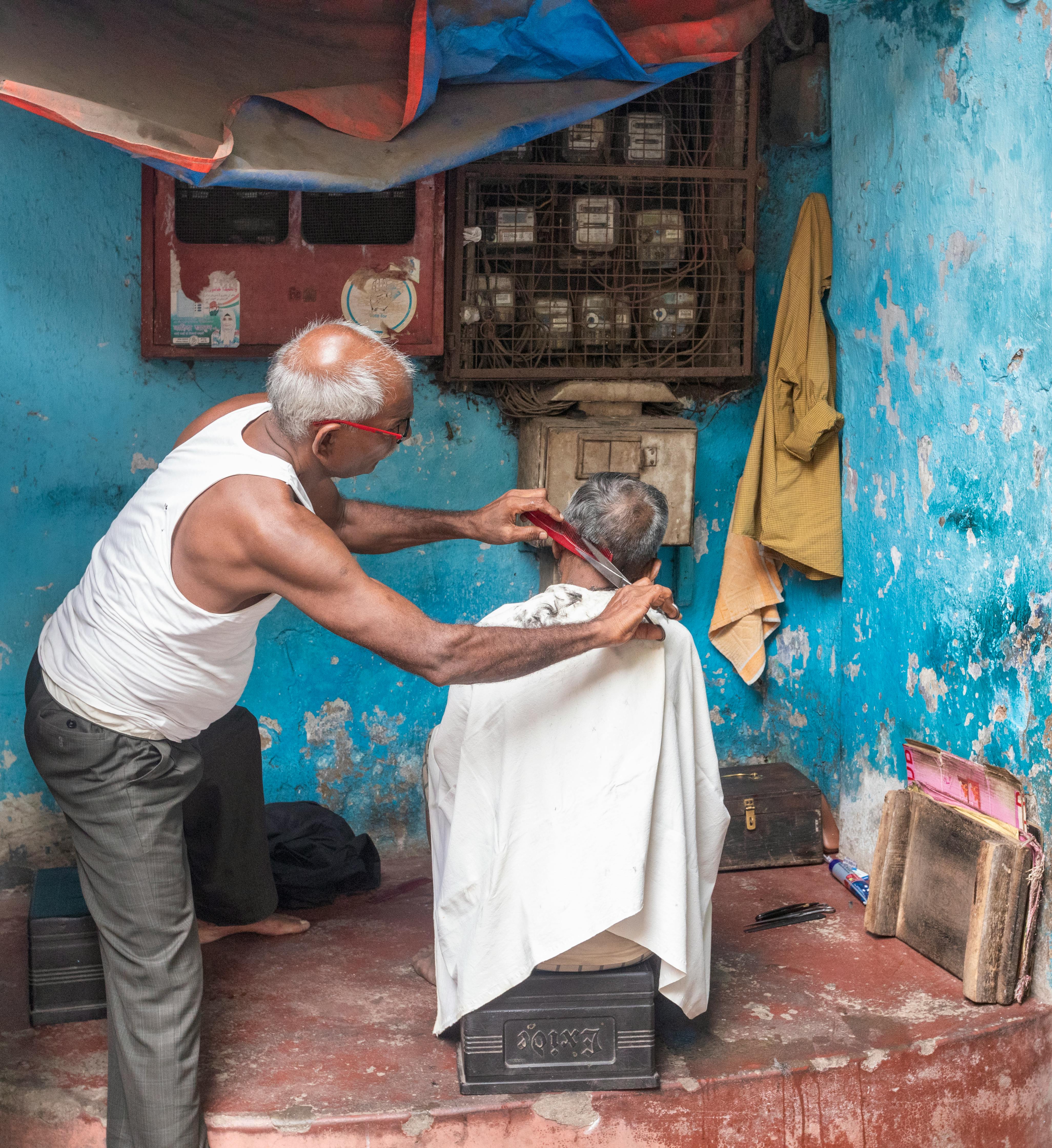 A man is cutting the hair of another man · Free Stock Photo