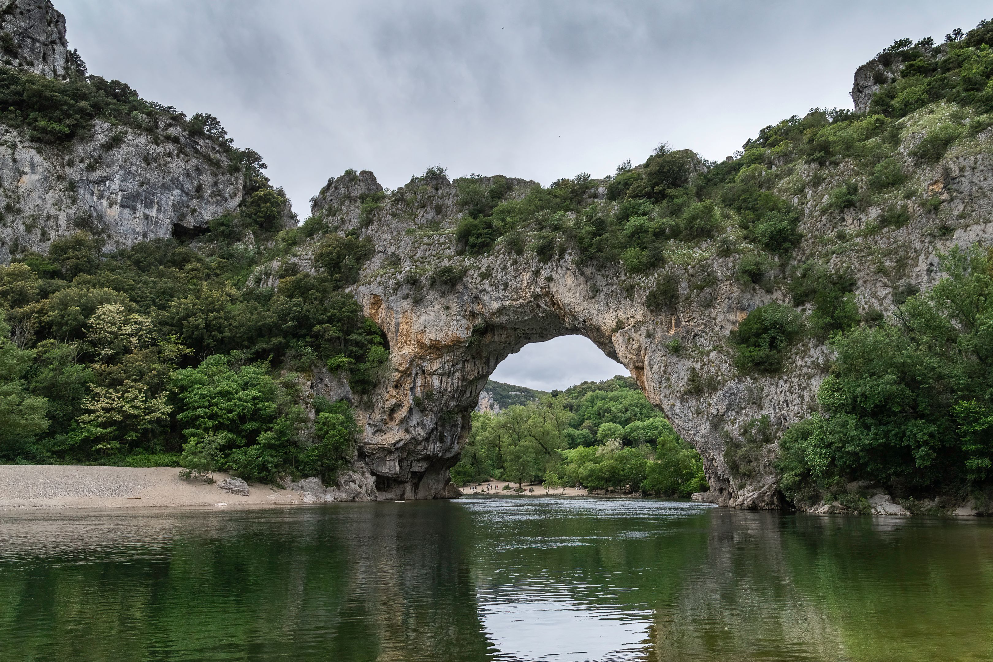 A large rock arch in the middle of a river · Free Stock Photo