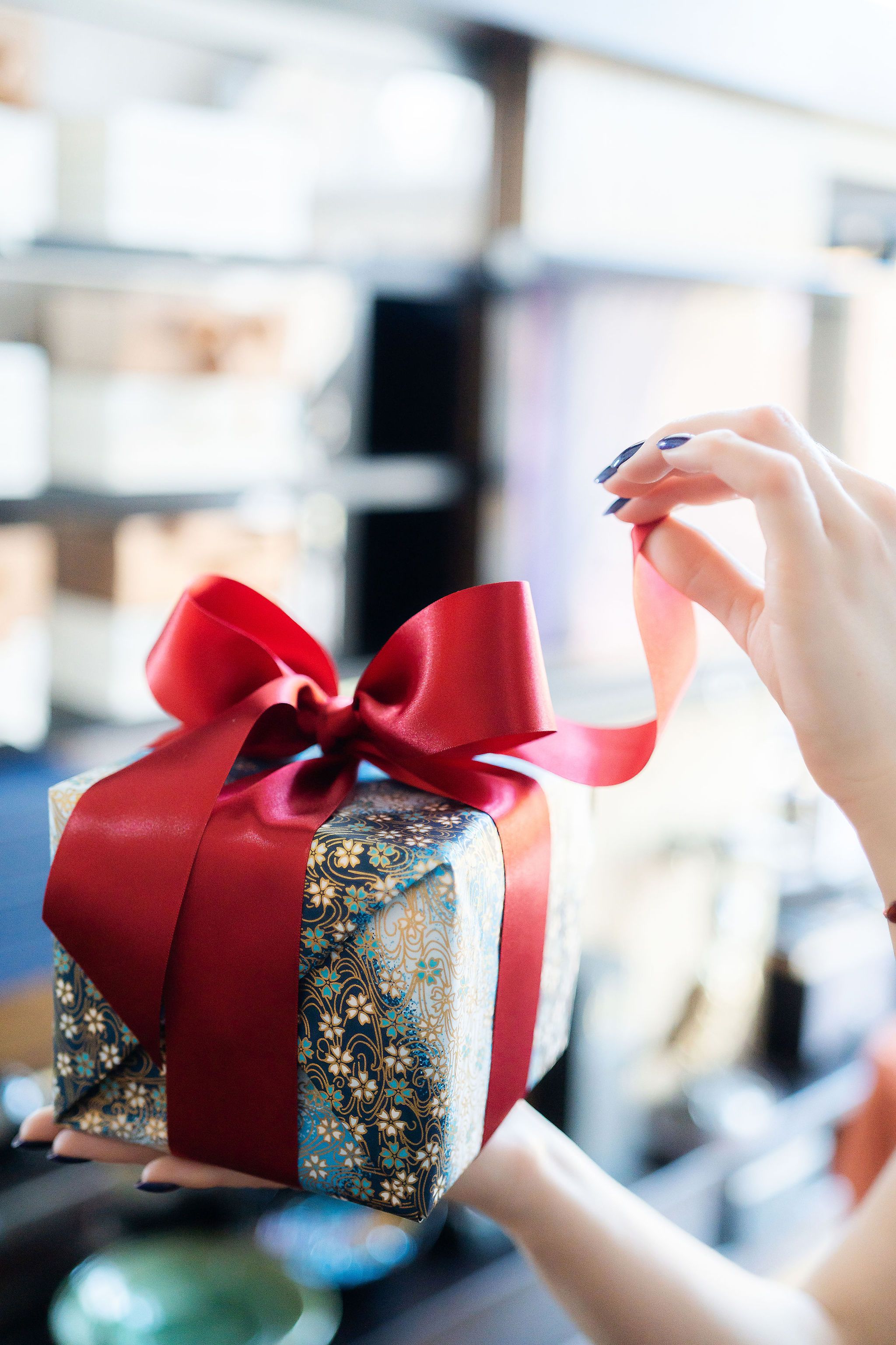 Hand Pulling a Ribbon of a Gift · Free Stock Photo