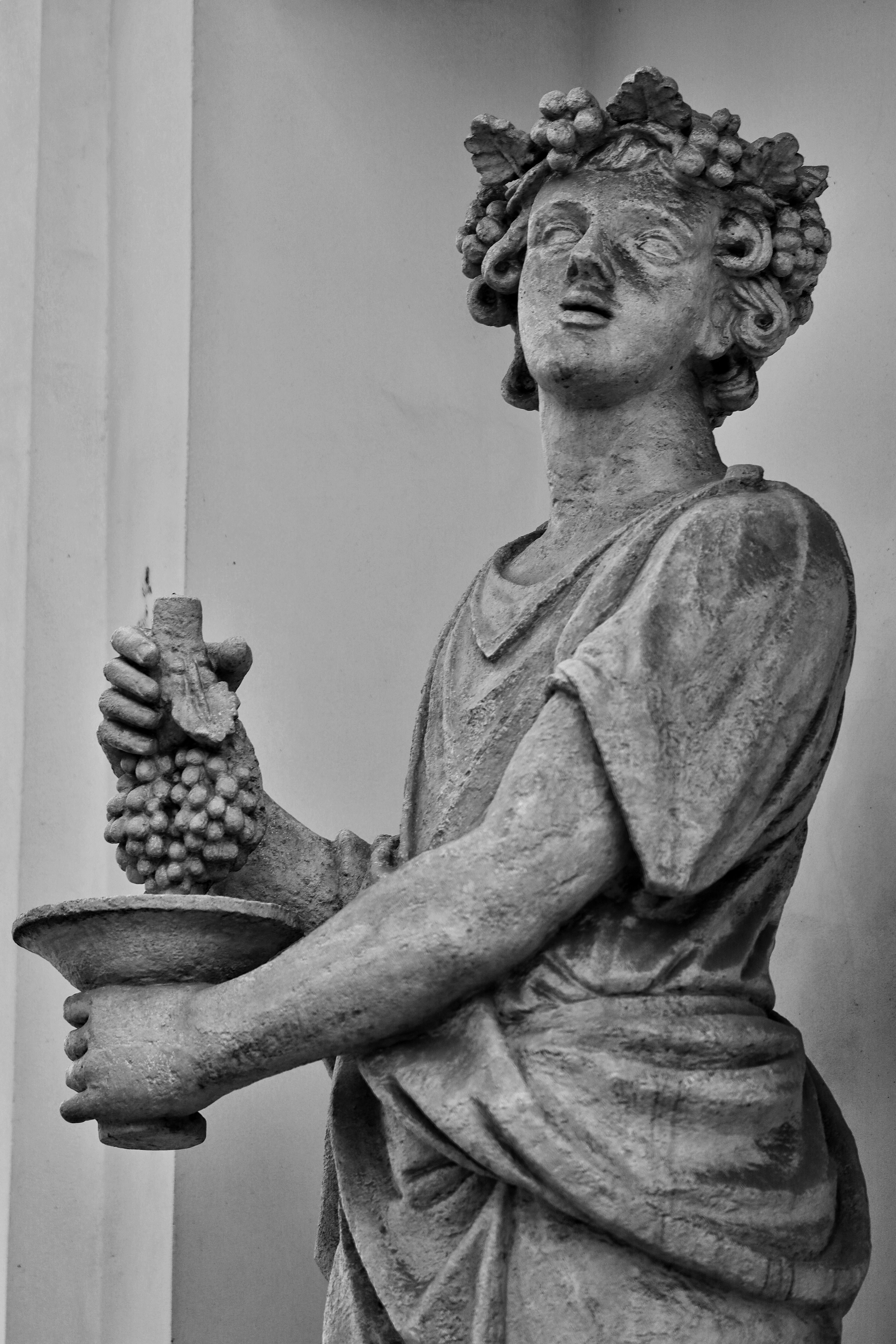 Sculpture of a Man Holding Grapes in Black and White · Free Stock Photo