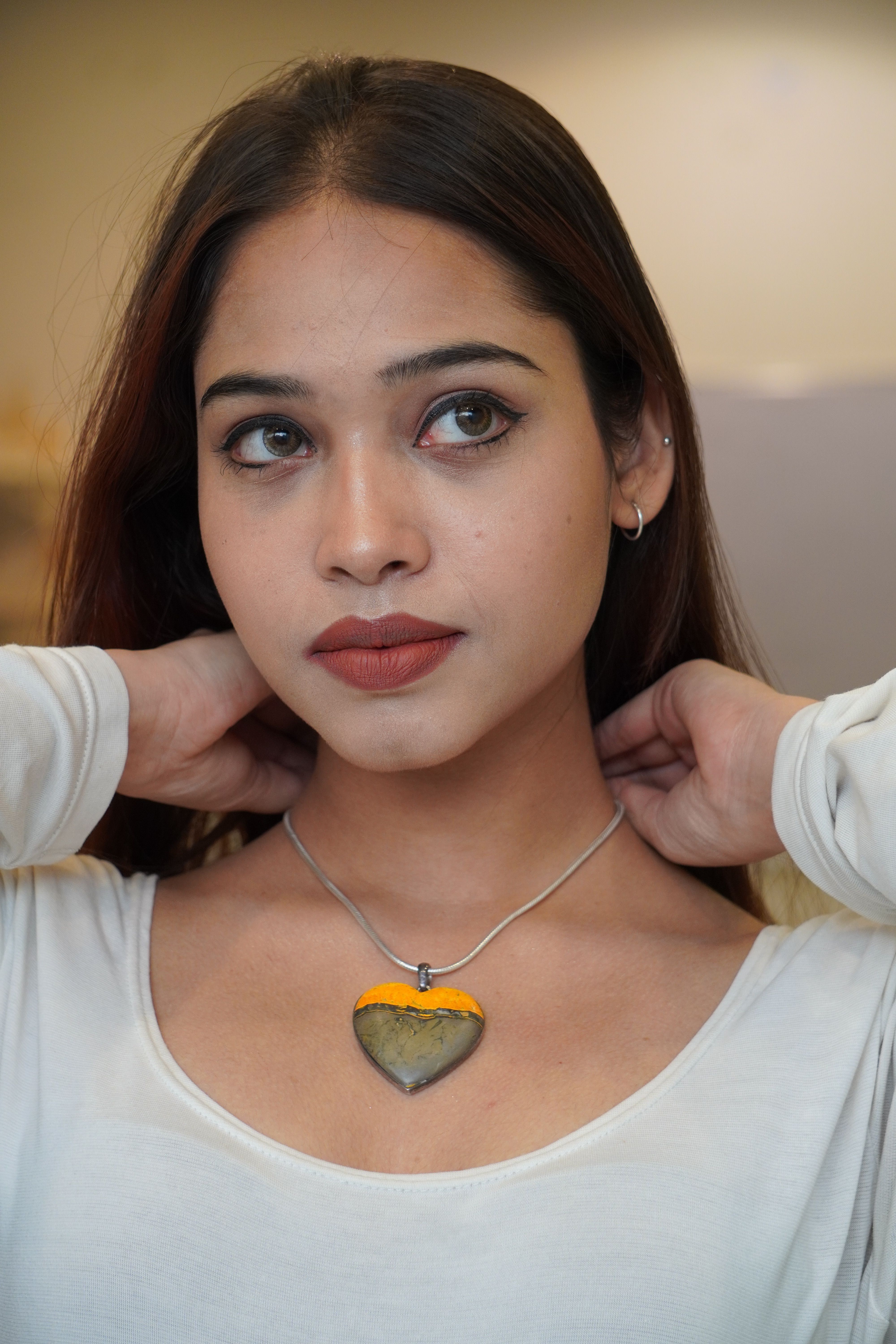 Brunette Woman Tying Heart Stone Necklace around her Neck · Free Stock ...