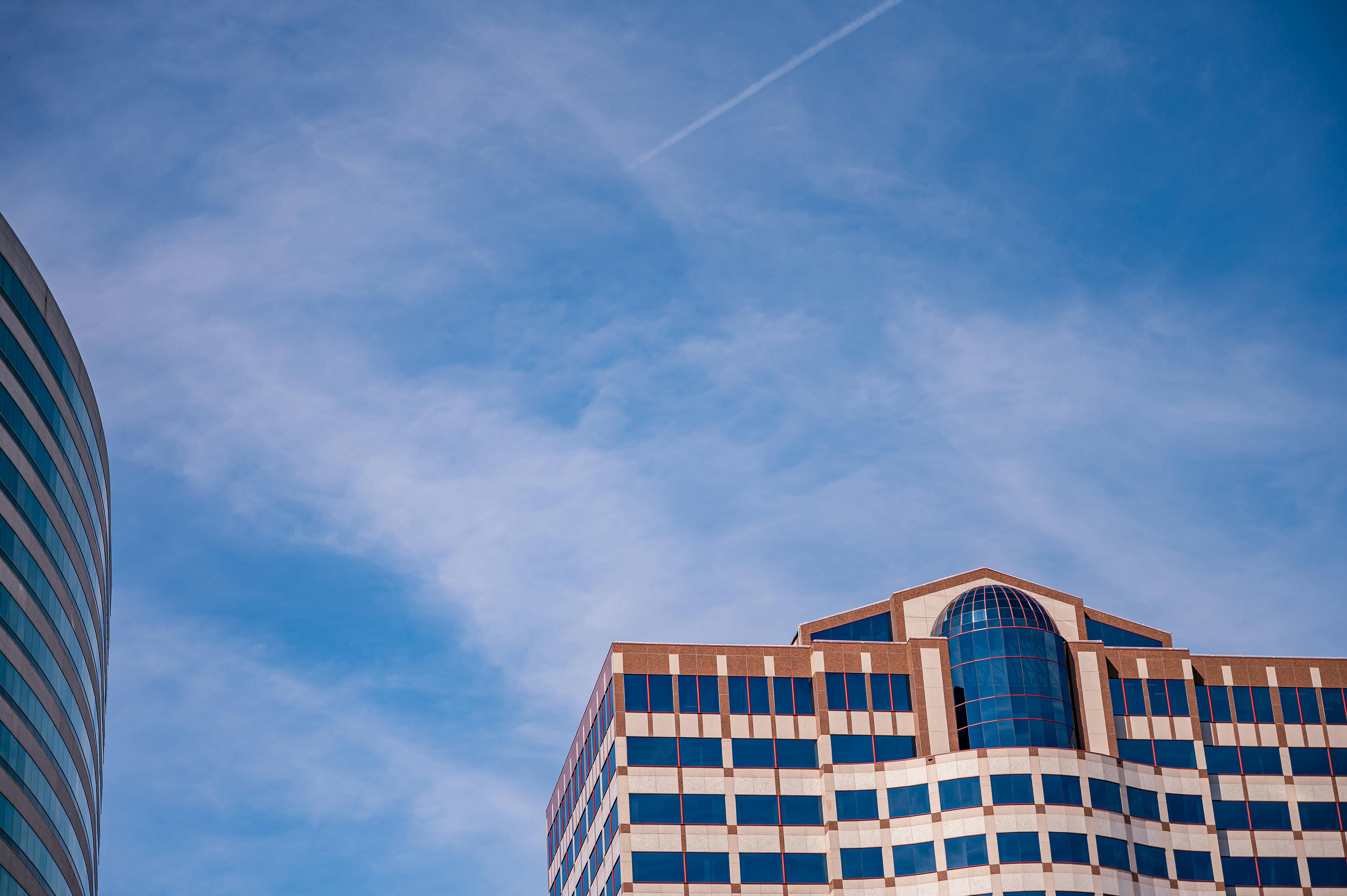 Low Angle Photo of Building Under Cloudy Sky · Free Stock Photo