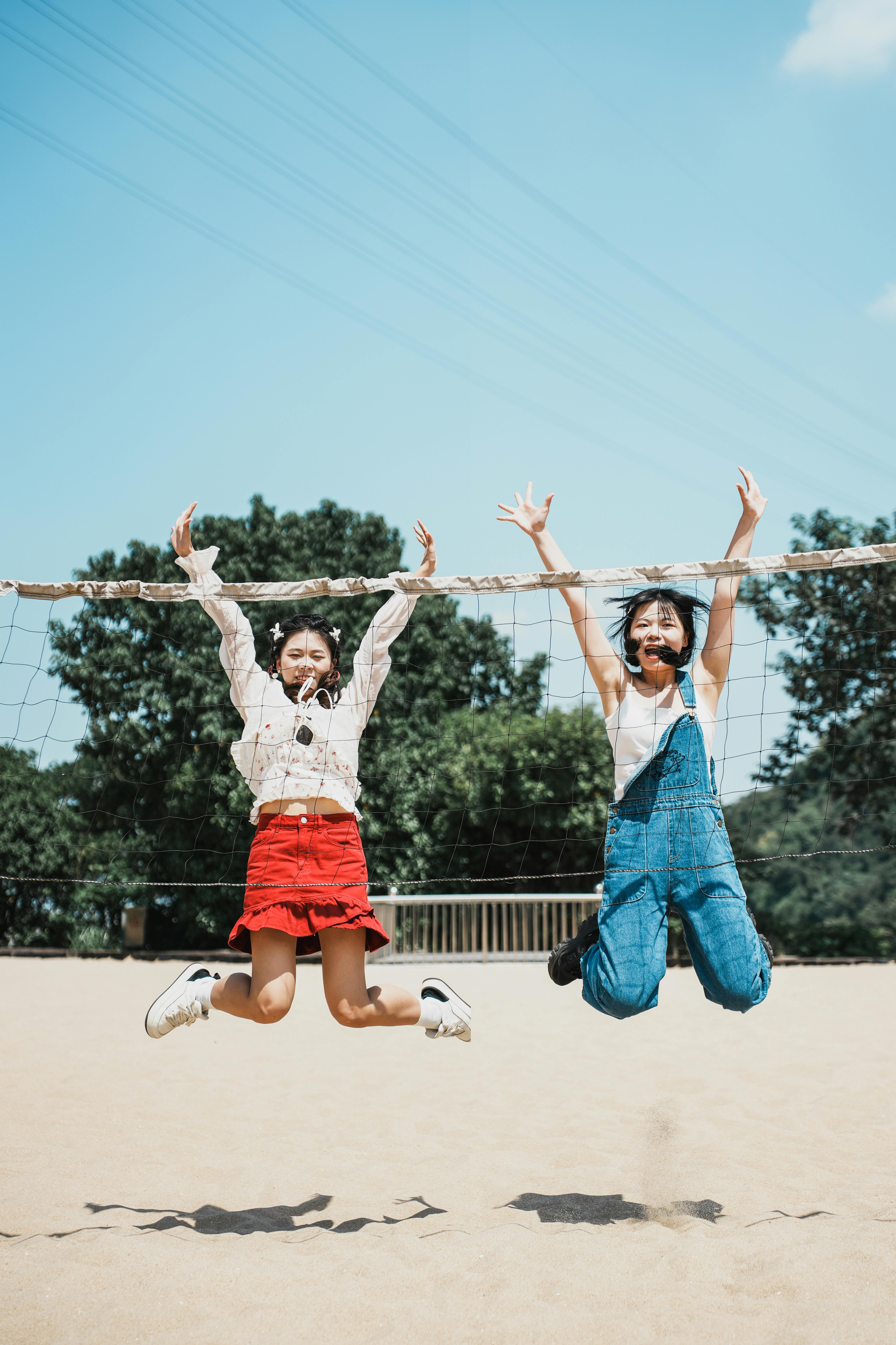 Girls Jumping behind Net at Beach · Free Stock Photo