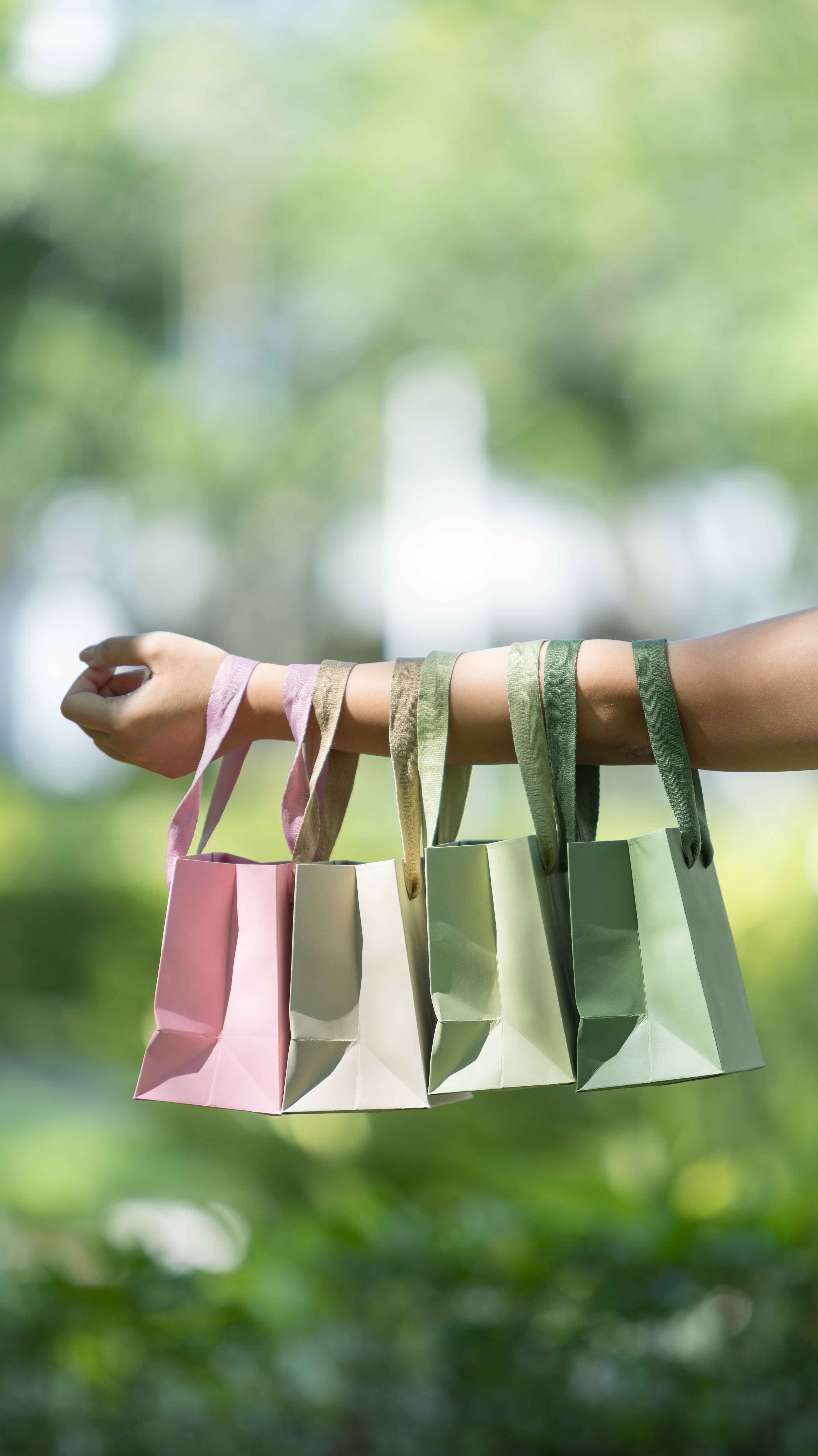 Close-up of Multi Colored Paper Gift Bags Hanging on a Womans Arm ...