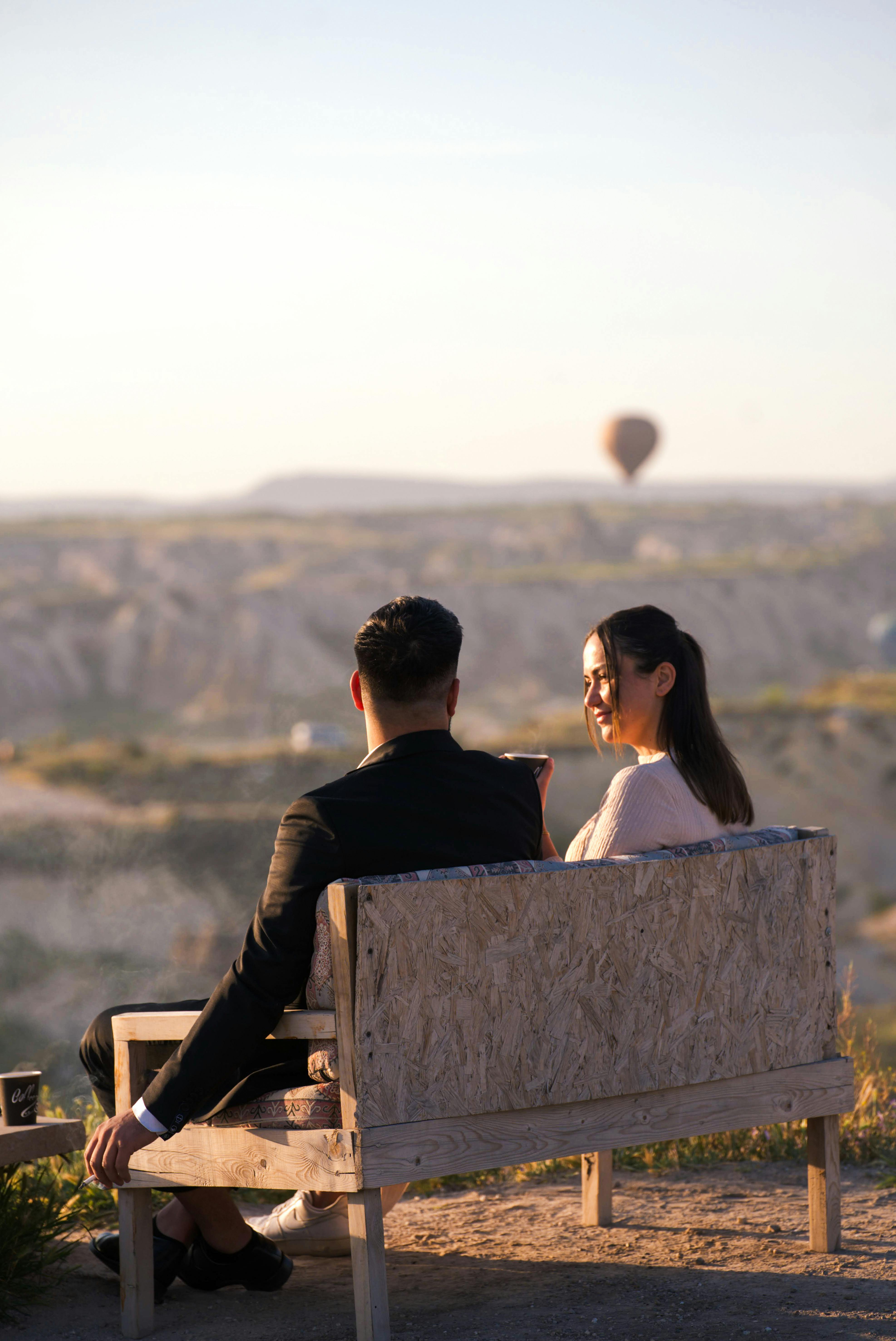 Couple Sitting on Wooden Bench Overlooking Canyon · Free Stock Photo