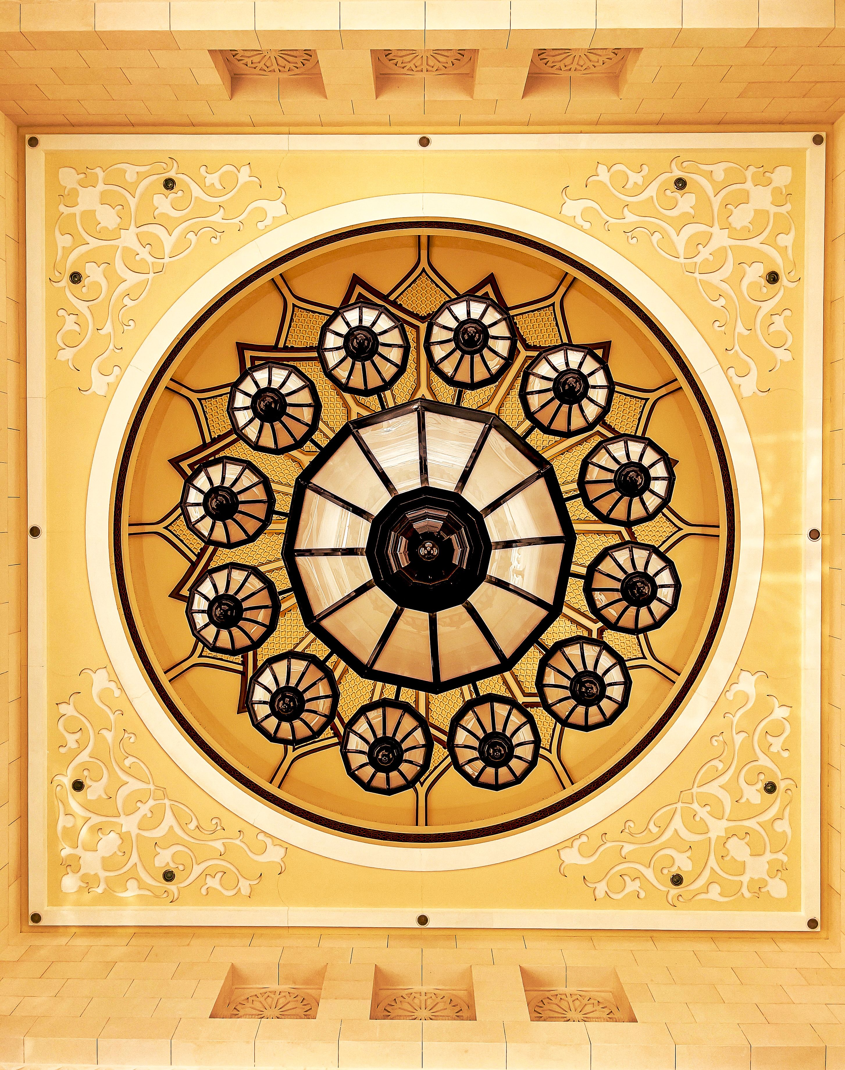 A clock with a circular design on the ceiling · Free Stock Photo