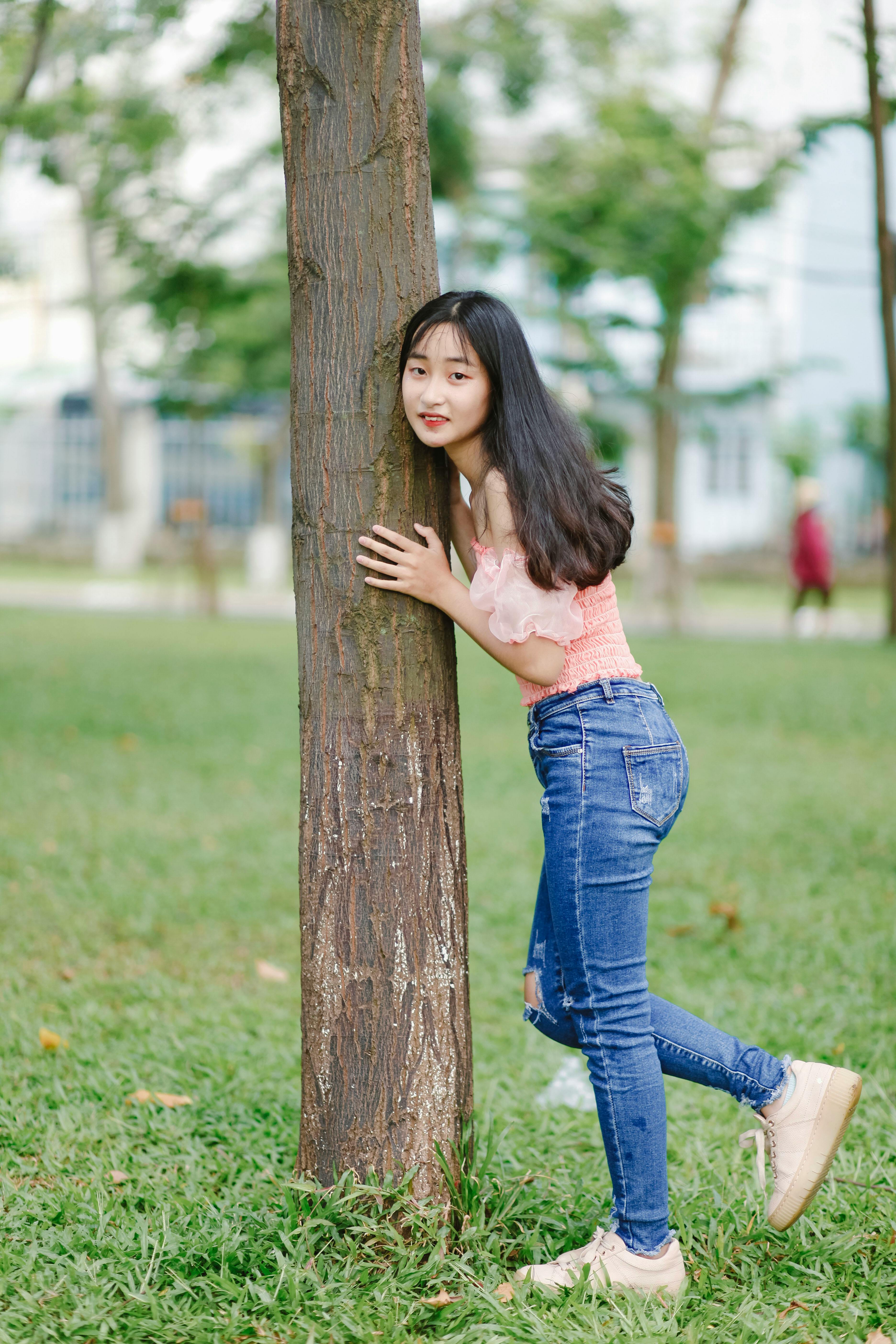 Woman Leaning on Tree at Park · Free Stock Photo