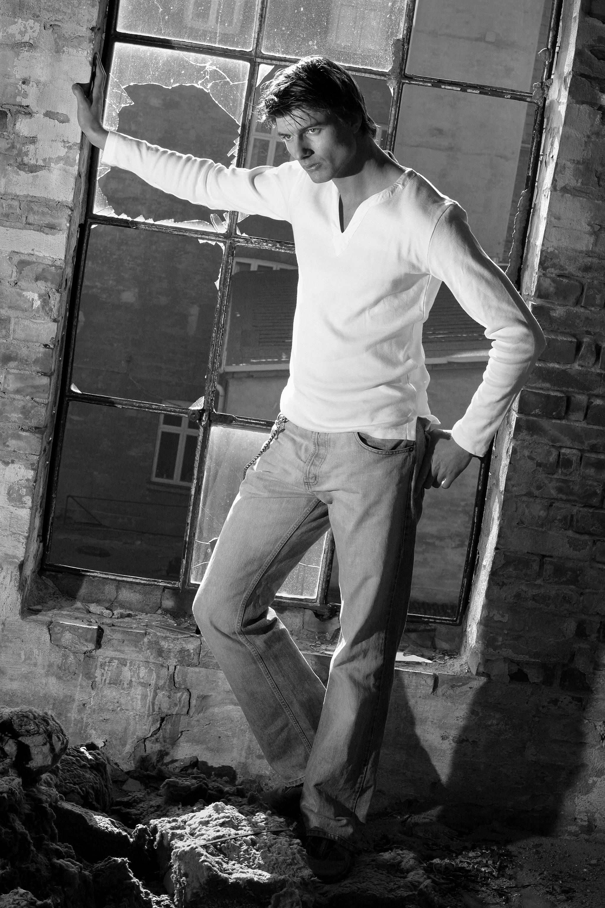 Grayscale Photo Of A Male Model By A Broken Window · Free Stock Photo