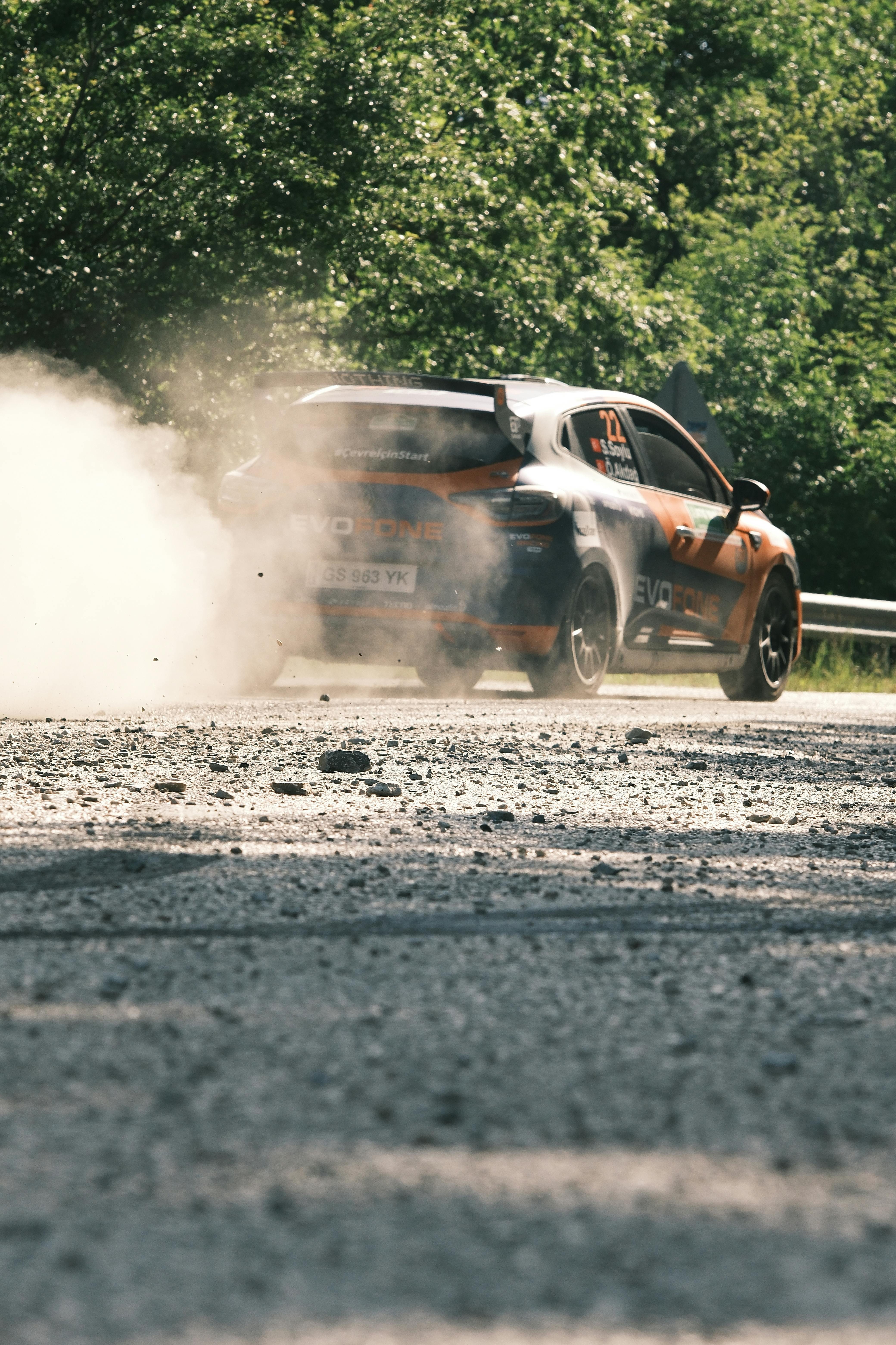 A car is driving on the road with smoke coming out of it · Free Stock Photo