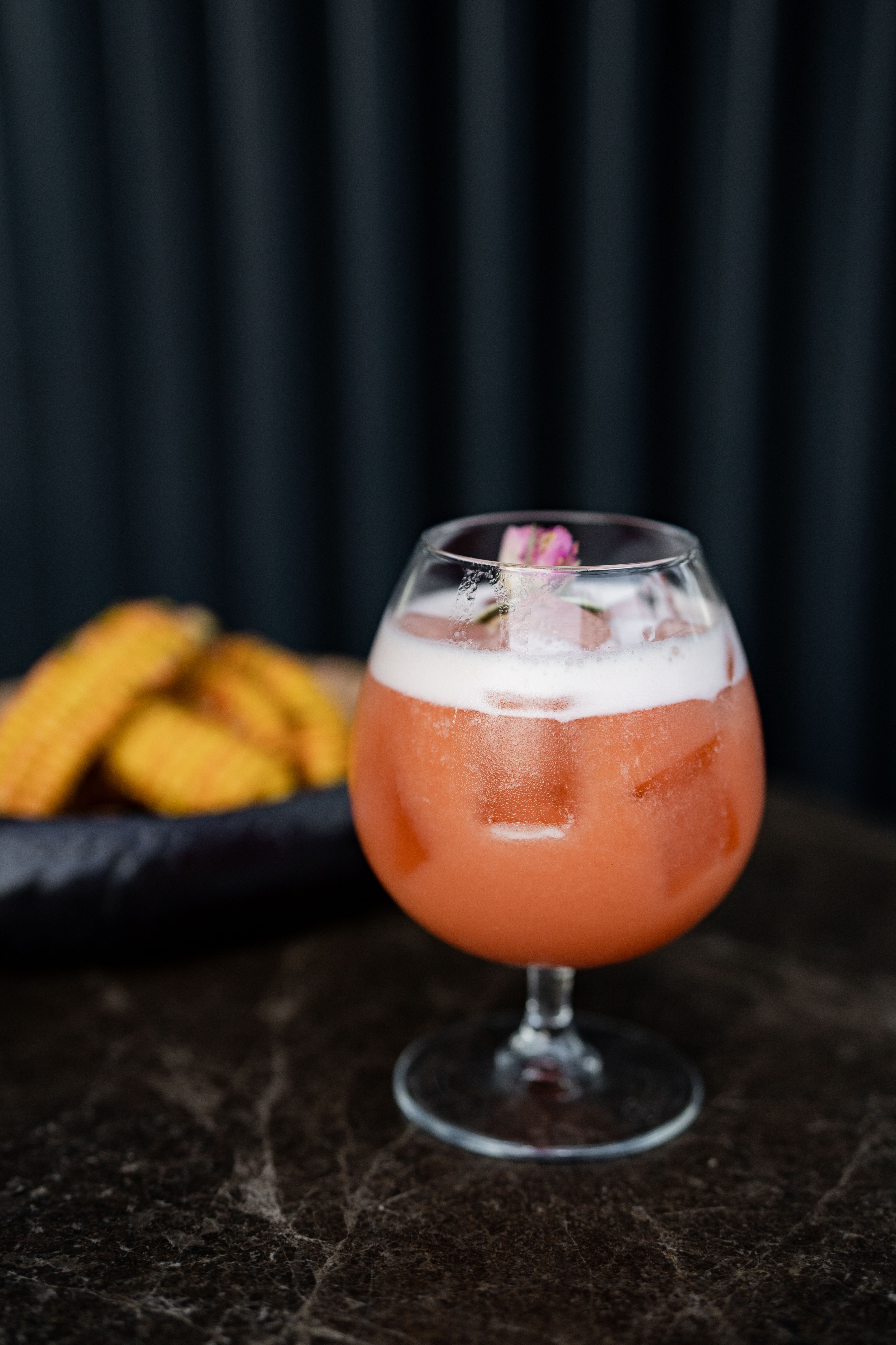 A cocktail with ice and garnish on a table · Free Stock Photo
