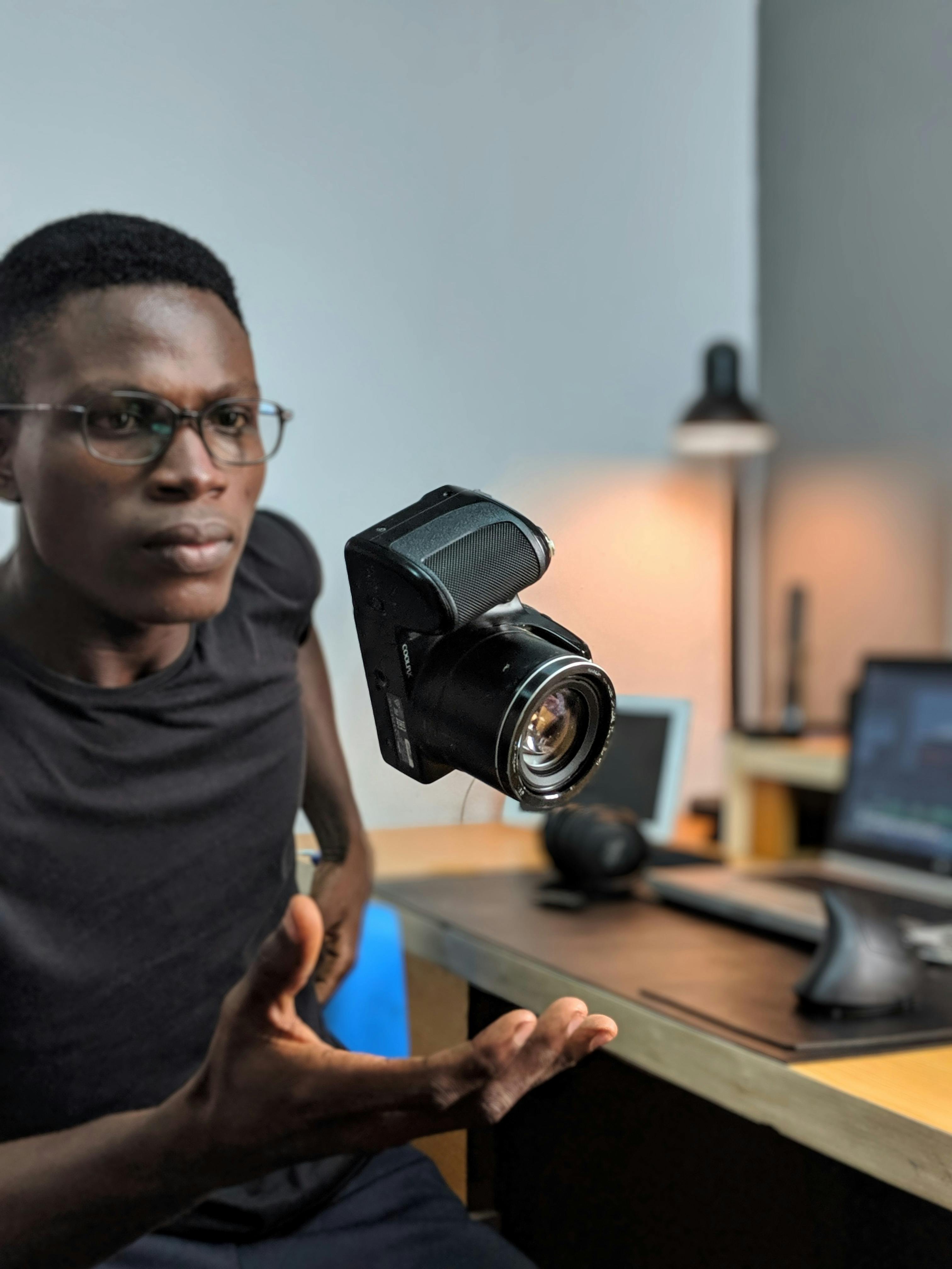 Man Sitting Near Camera · Free Stock Photo