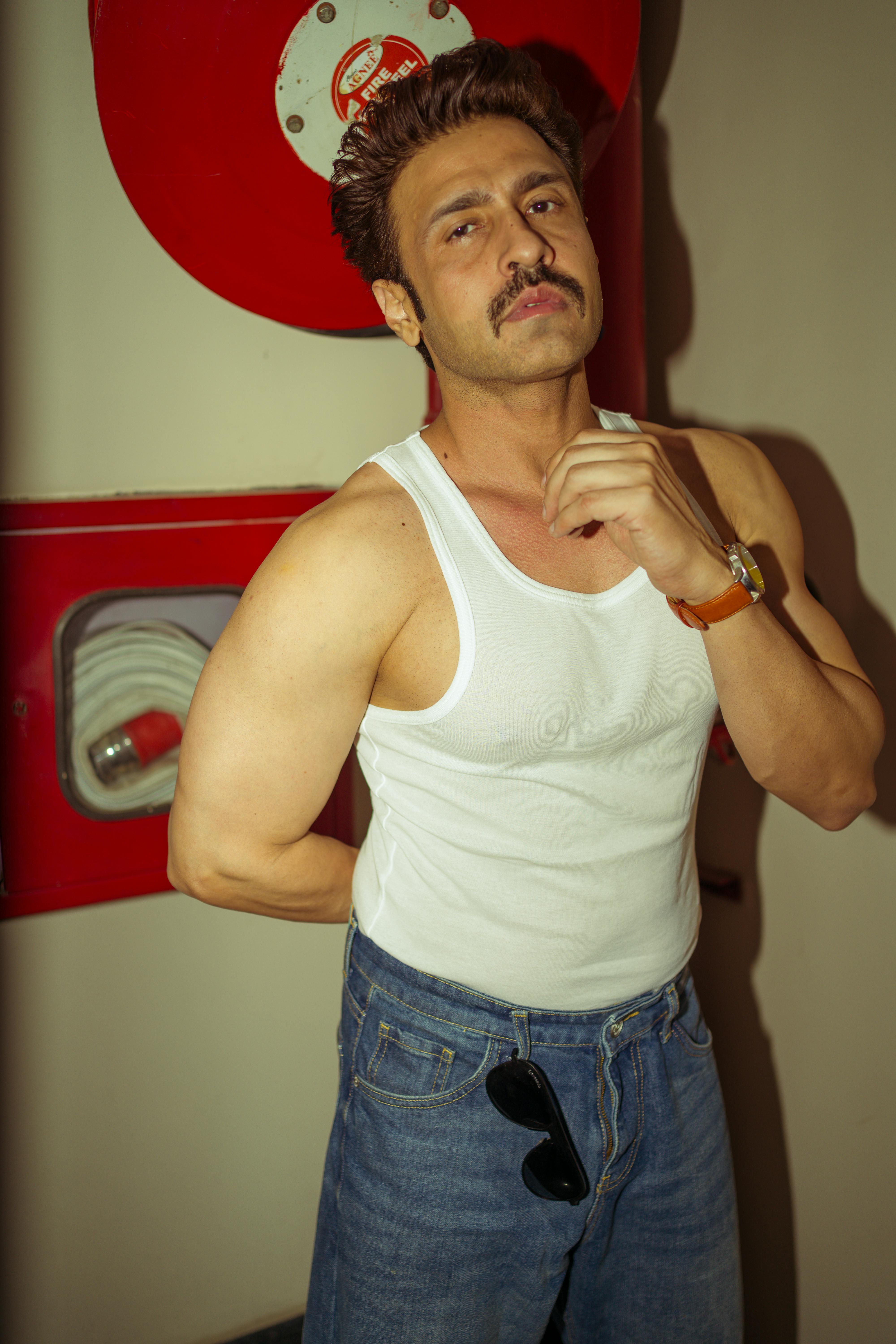 Muscular Man with Mustache Posing Wearing White Undershirt and Jeans ...