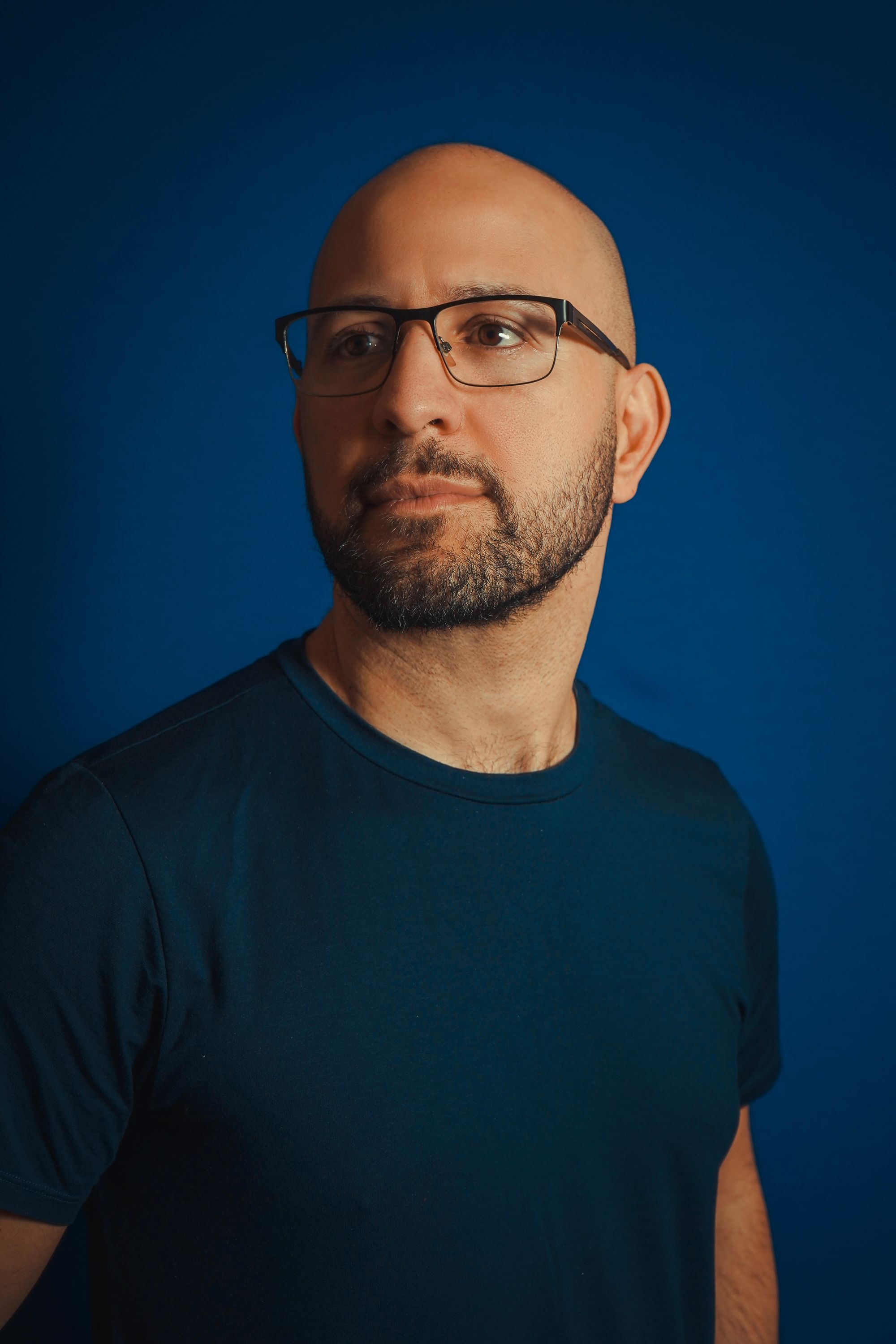 Portrait of a Bald Man against a Blue Wall · Free Stock Photo
