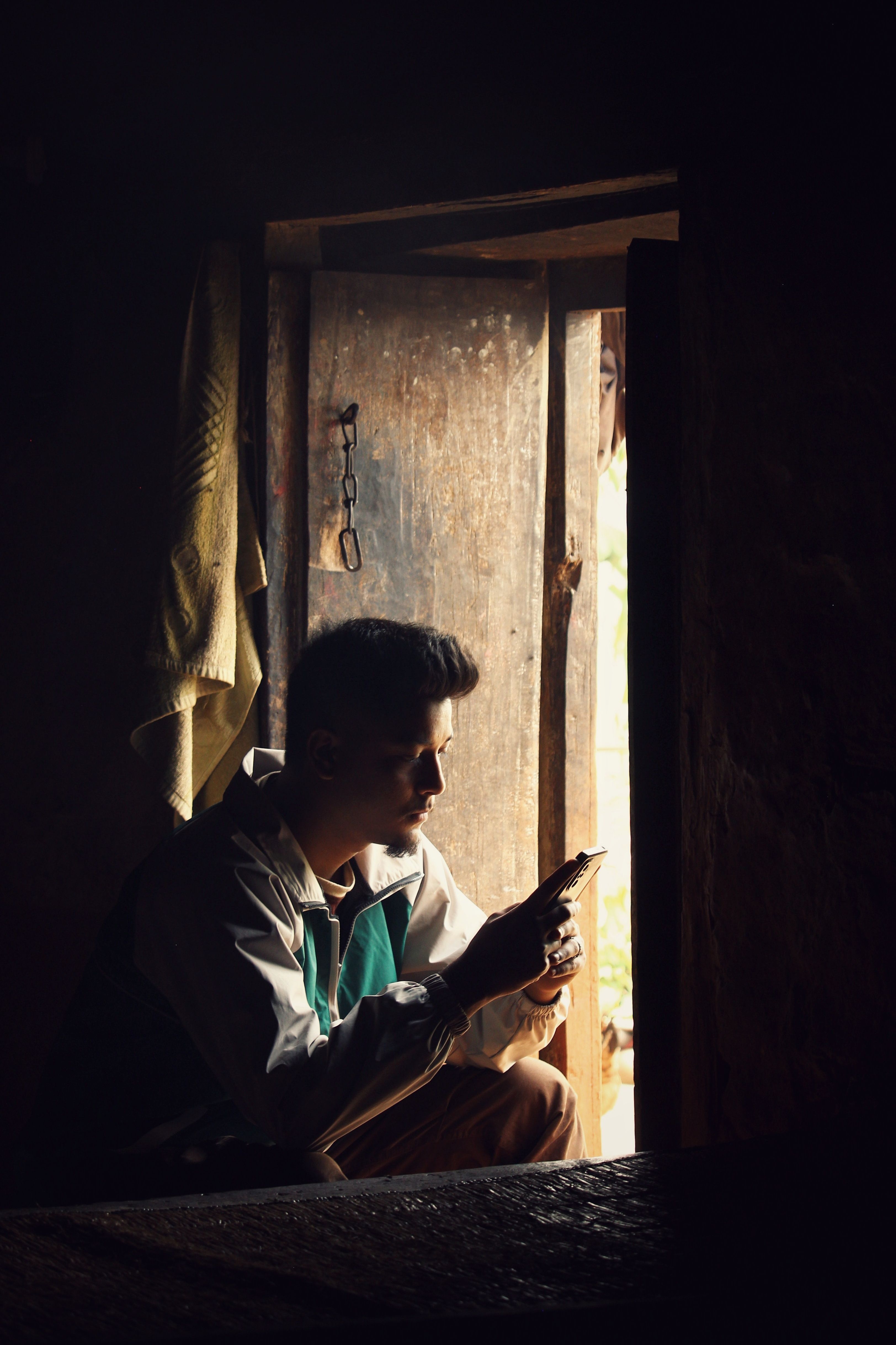 Man Sitting with Smartphone in Darkness · Free Stock Photo