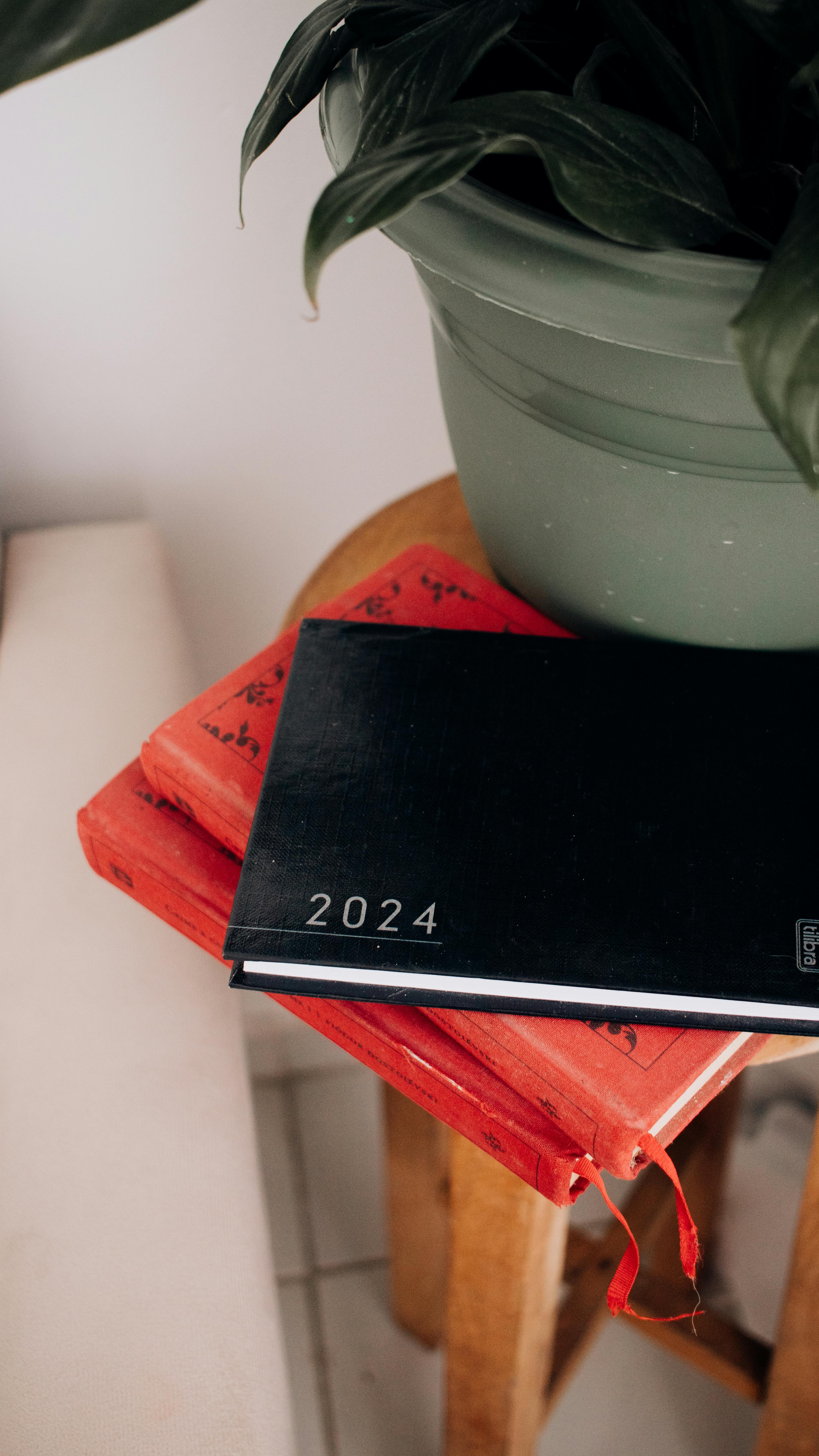 Journals and Calender on a Small Wooden Table Next to a Pot with a ...