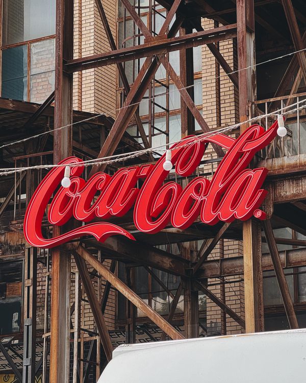 Light Bulbs Hanging in Front of a Coca-Cola Sign · Free Stock Photo