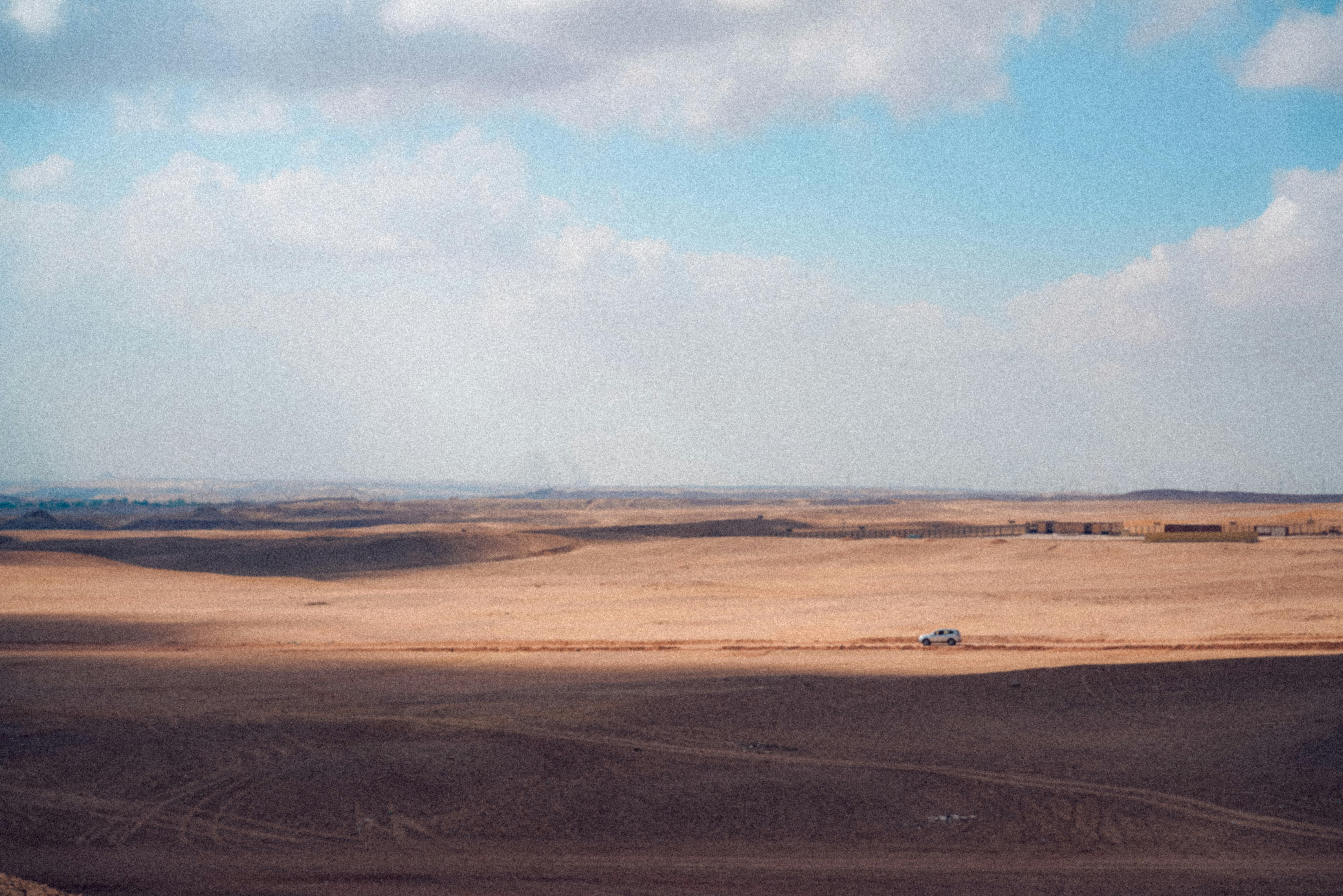 Distant Car Driving through the Desert · Free Stock Photo