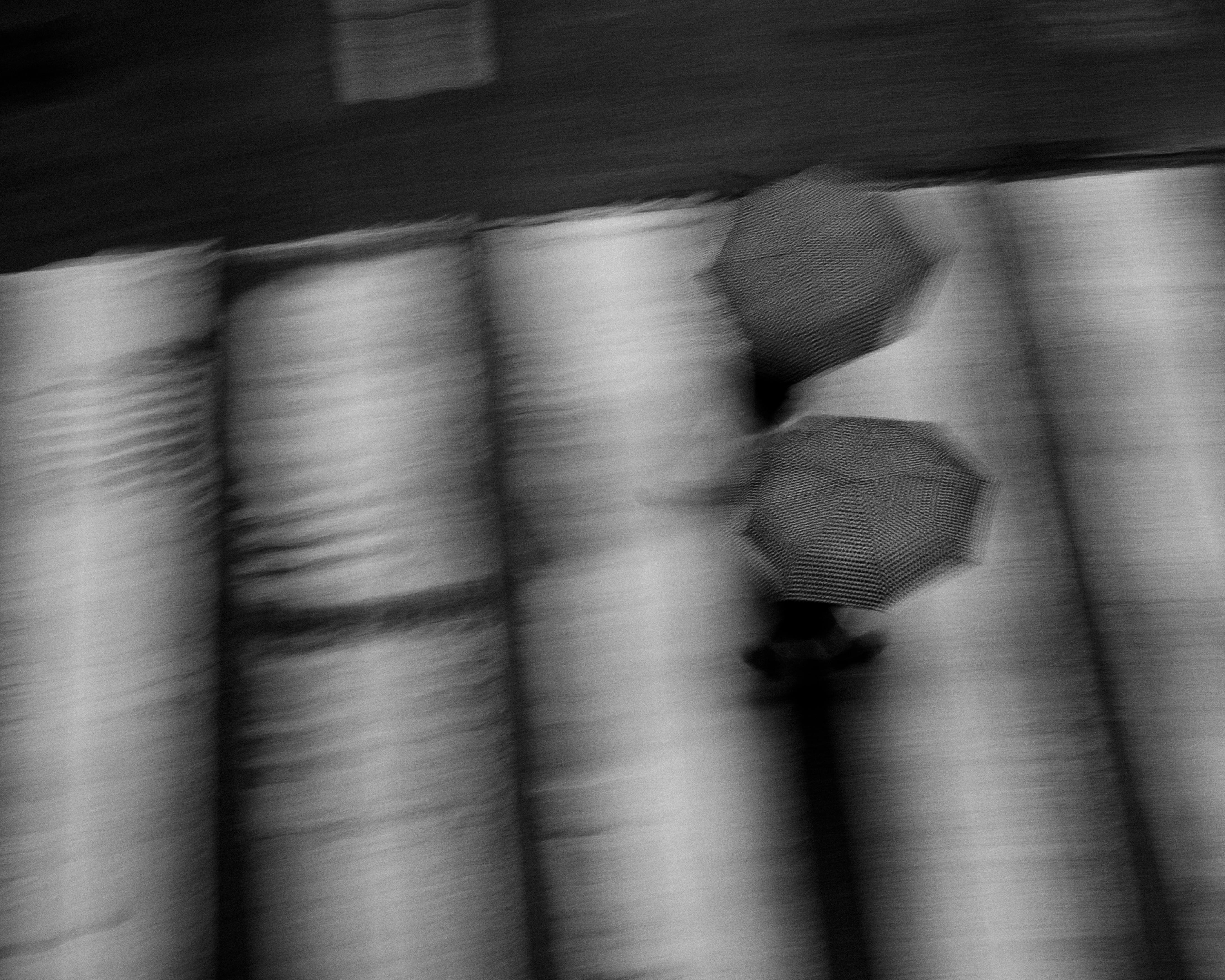 Blurred Motion Shot of Two People with Umbrellas · Free Stock Photo