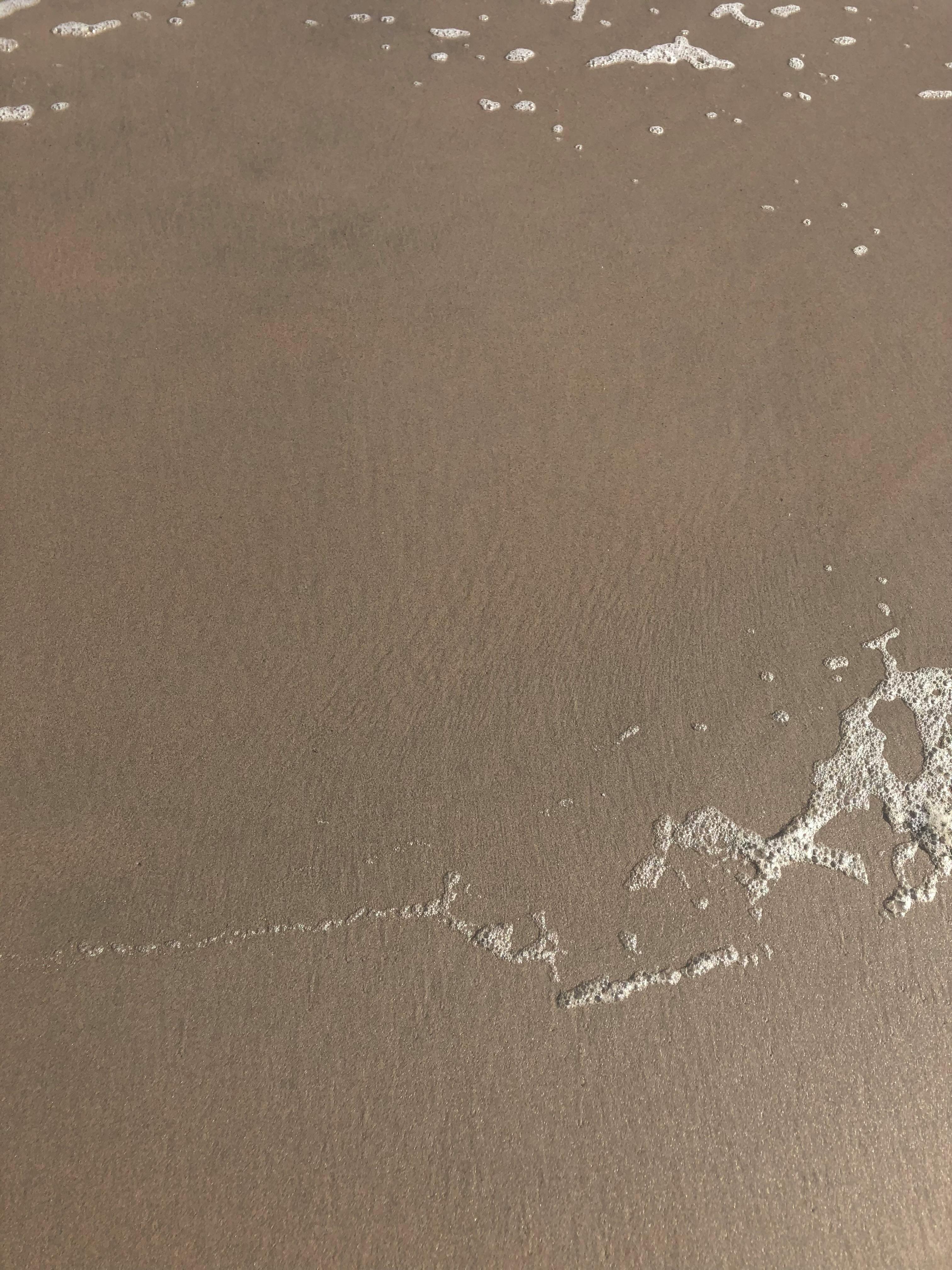Sea Foam on Smooth Sand Surface · Free Stock Photo