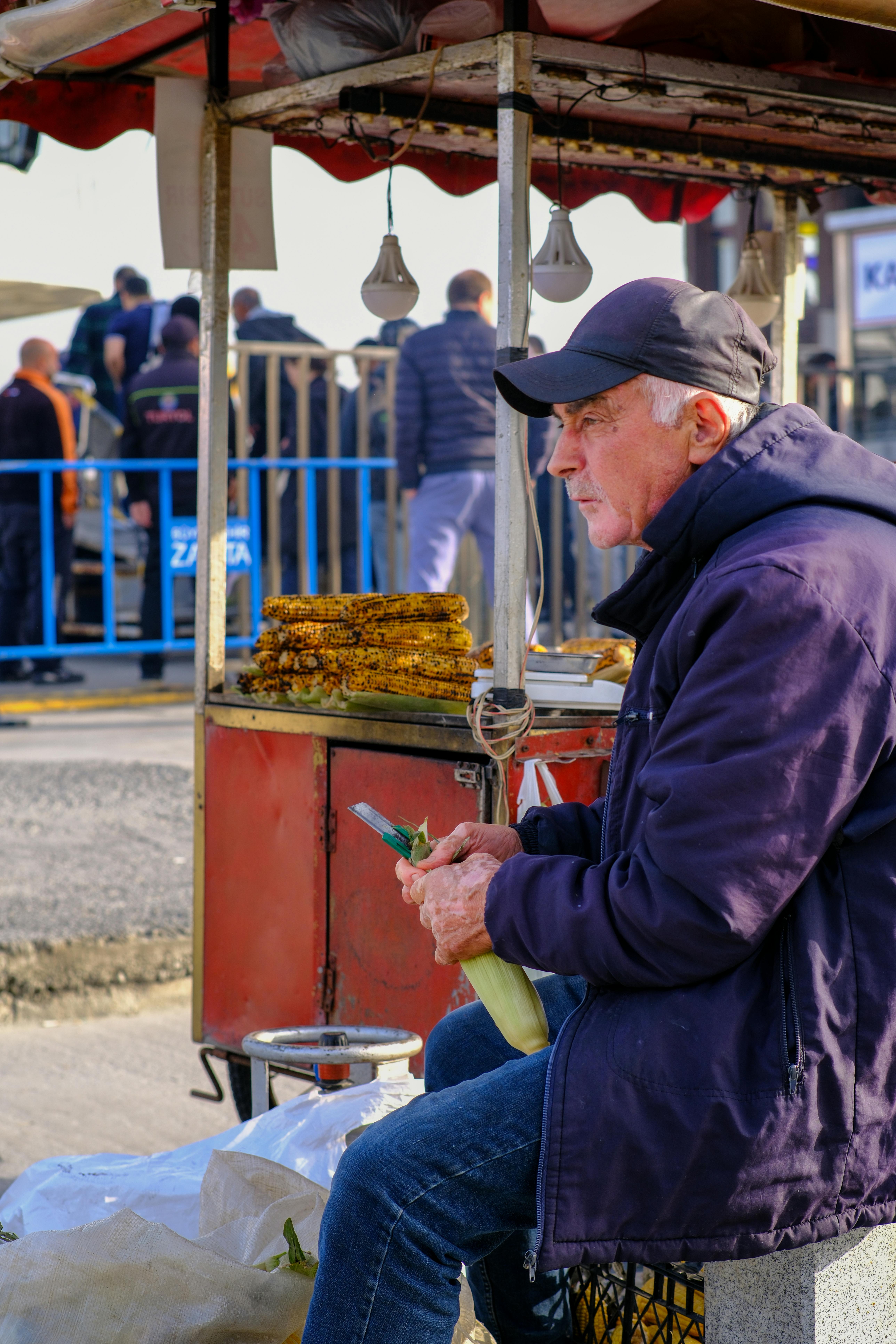 Side View of a Man Next to a Food Stand · Free Stock Photo