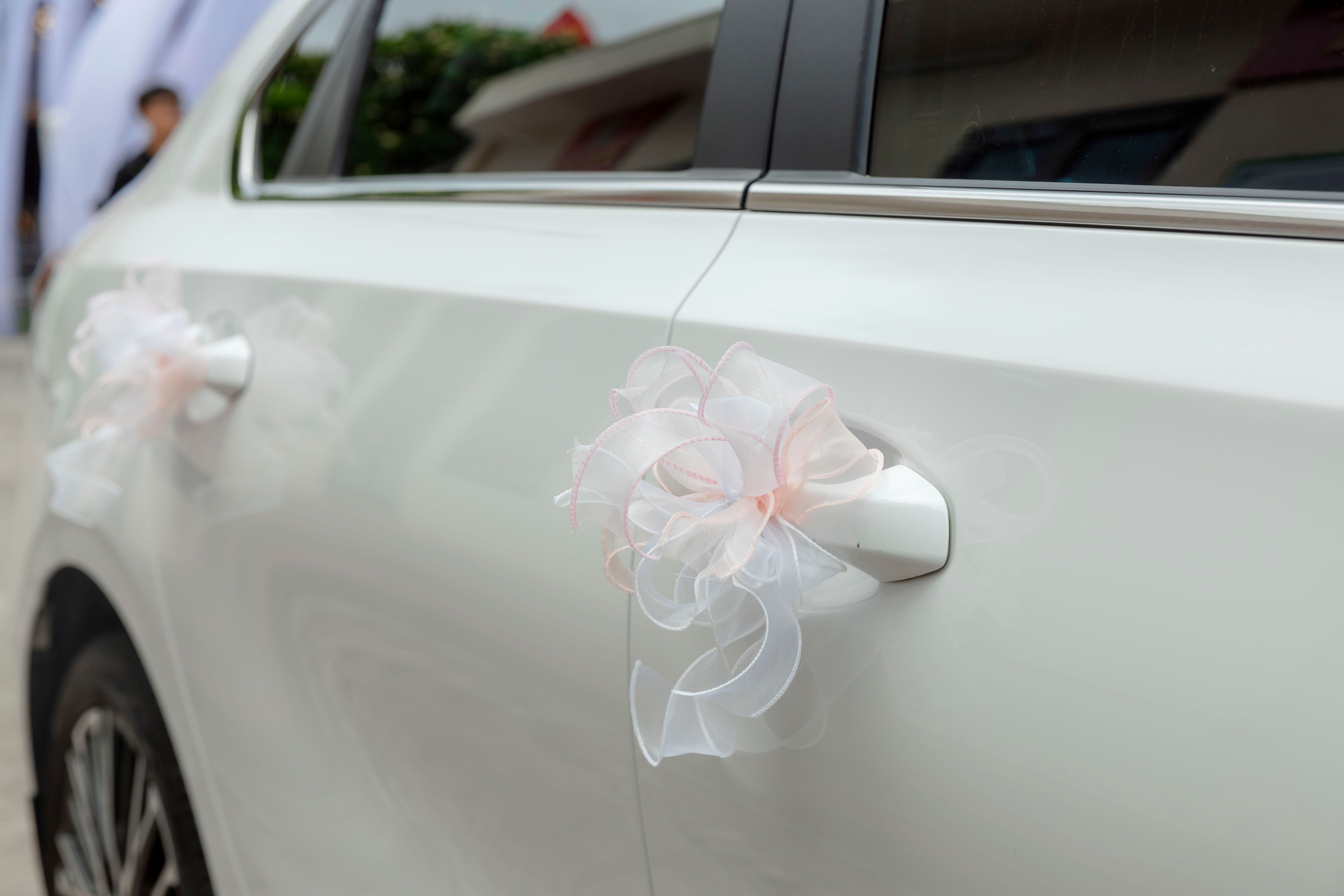 A white car with pink ribbons on the door · Free Stock Photo