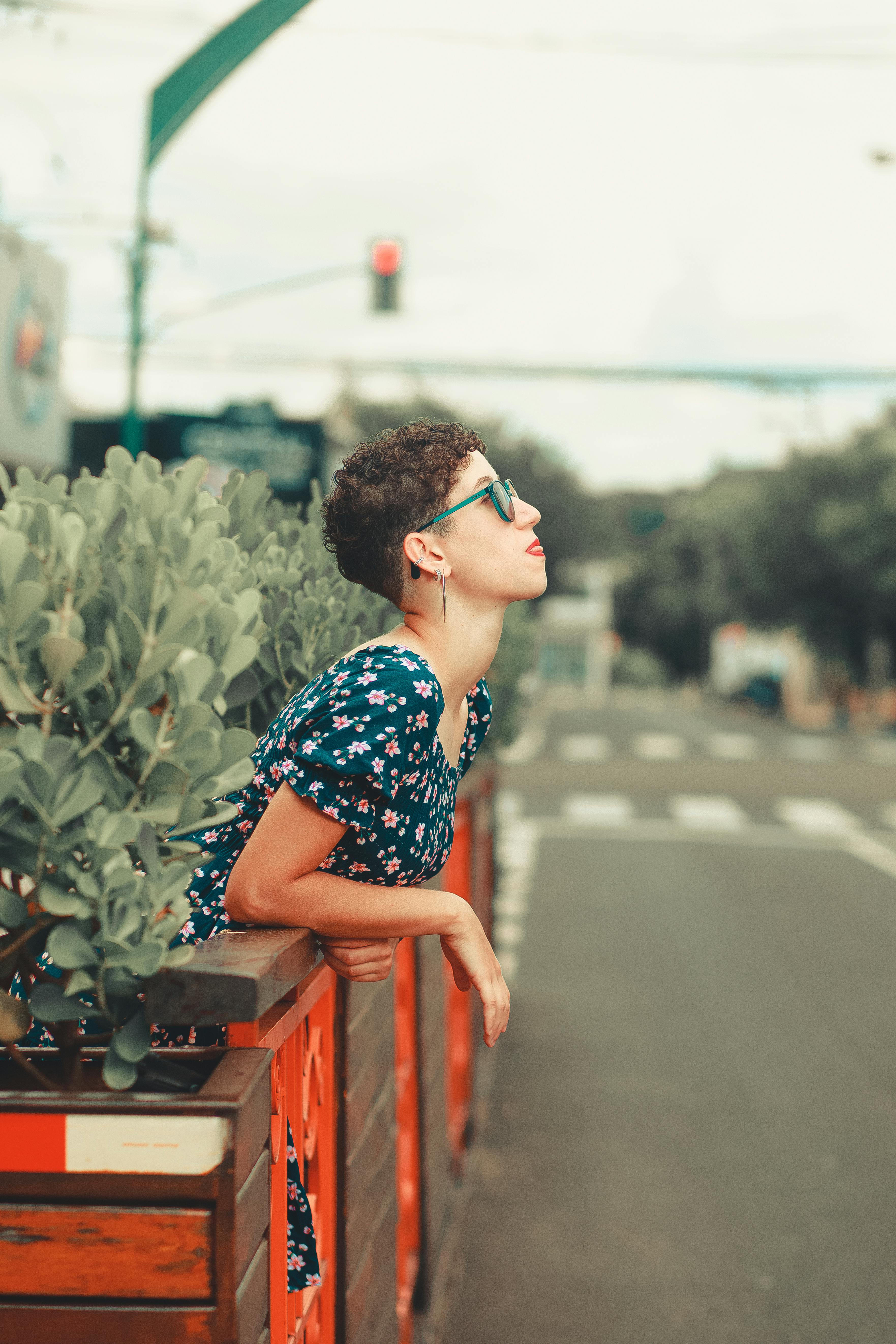 A Woman Hunched over the Patio Balustrade · Free Stock Photo