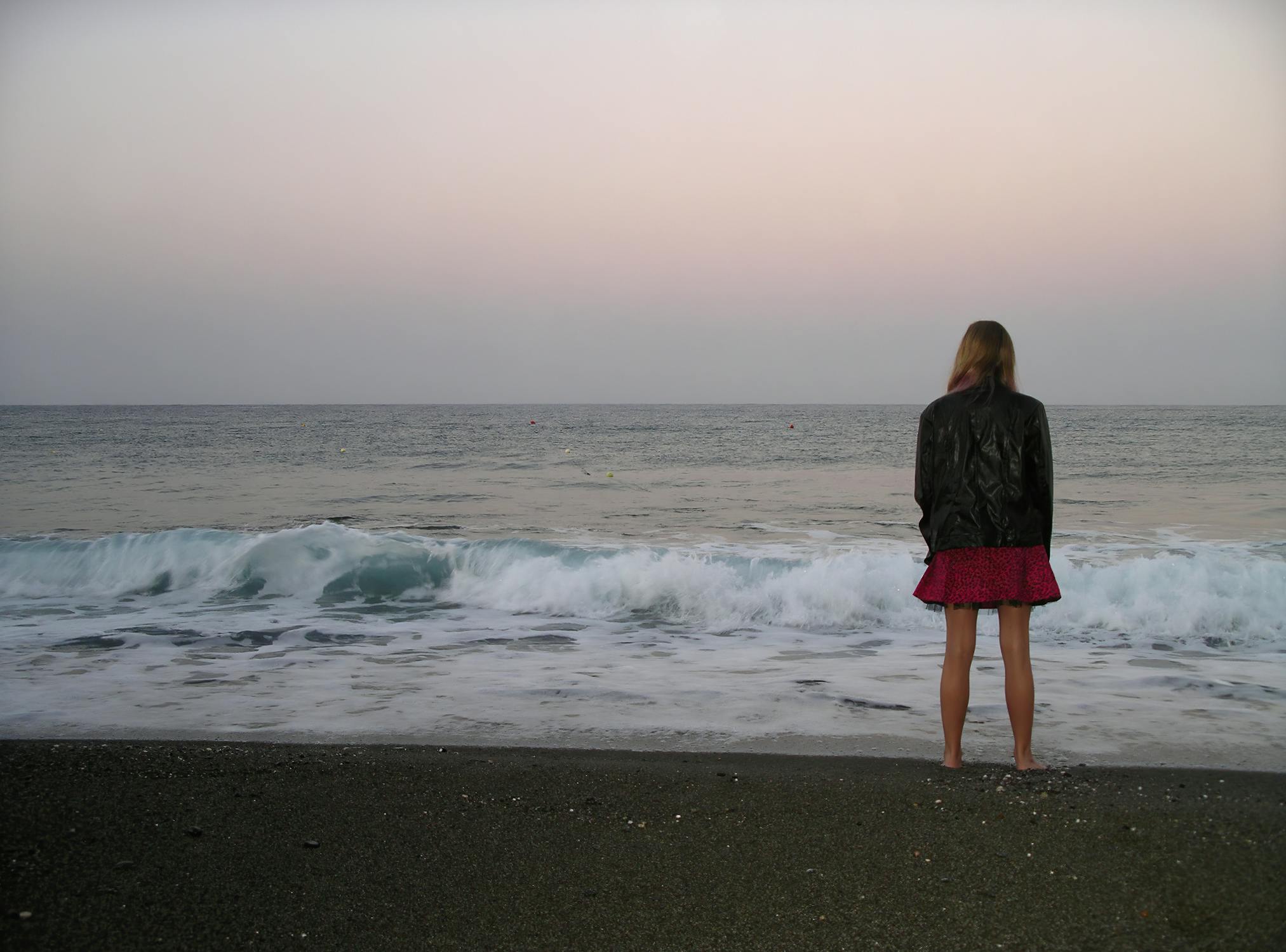 Back View Photo Of Barefoot Woman In Black Leather Jacket And Standing