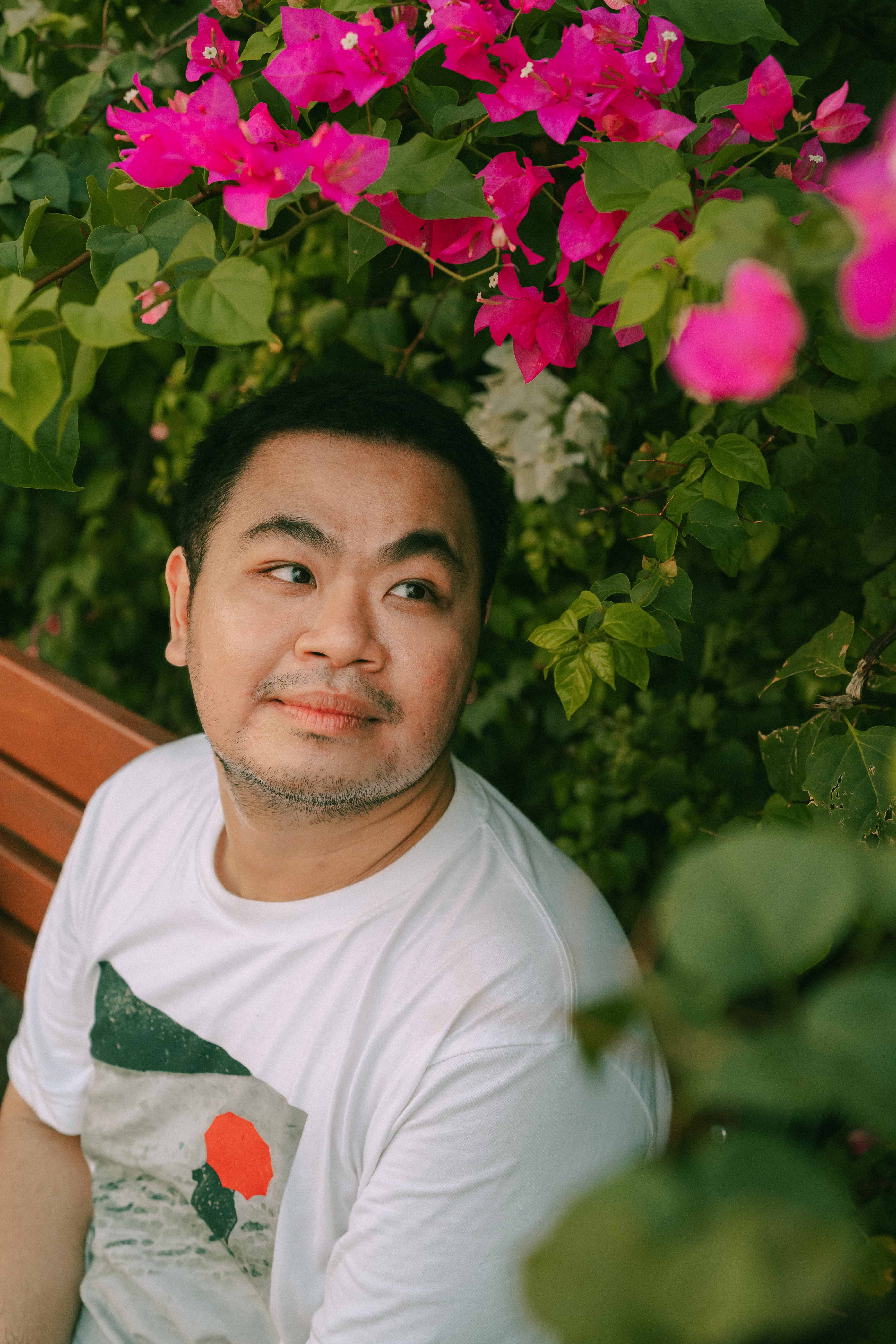 Portrait of Man Sitting Among Shrubs in a Park · Free Stock Photo