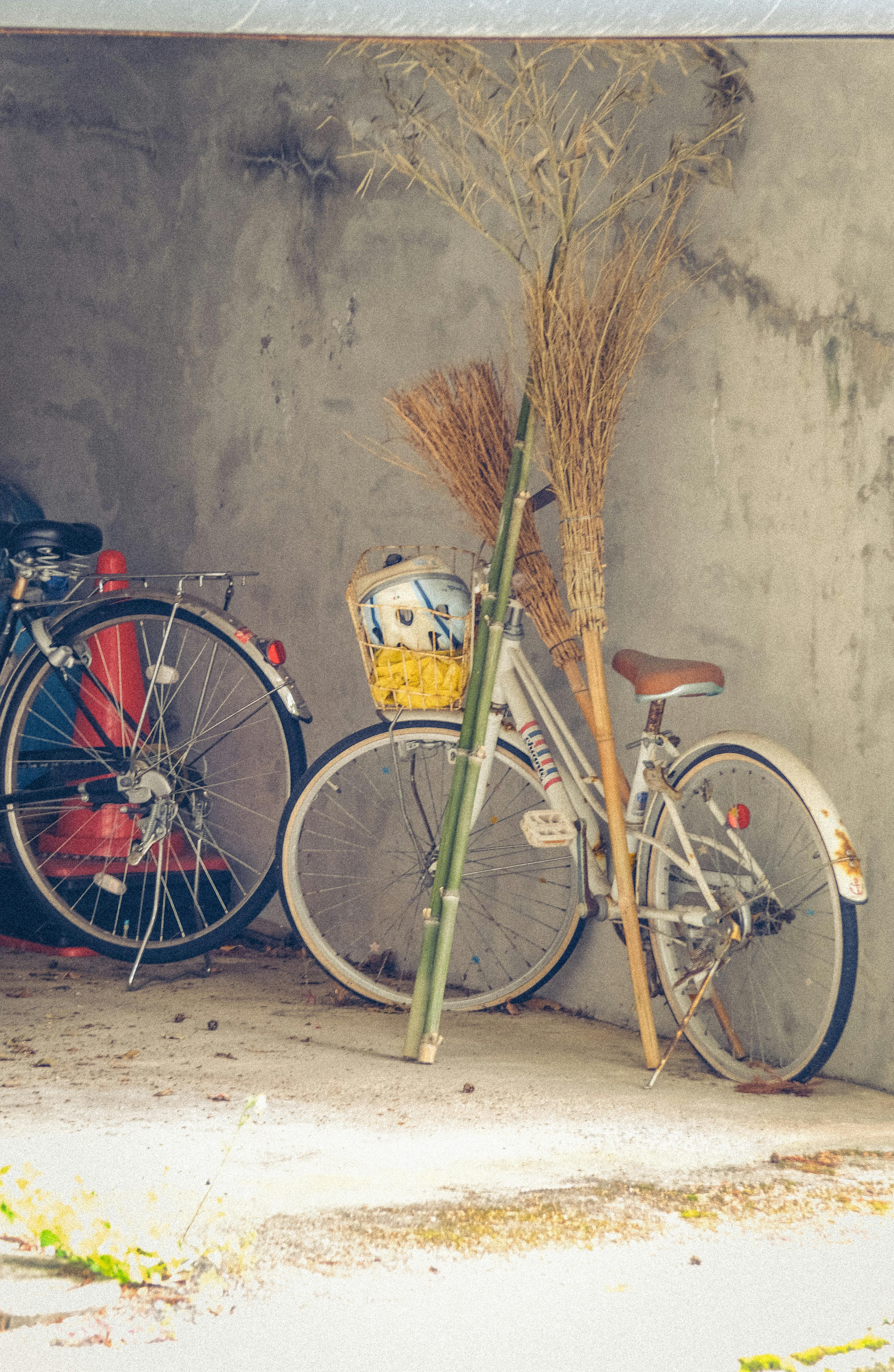 Bikes and Brooms near Wall · Free Stock Photo