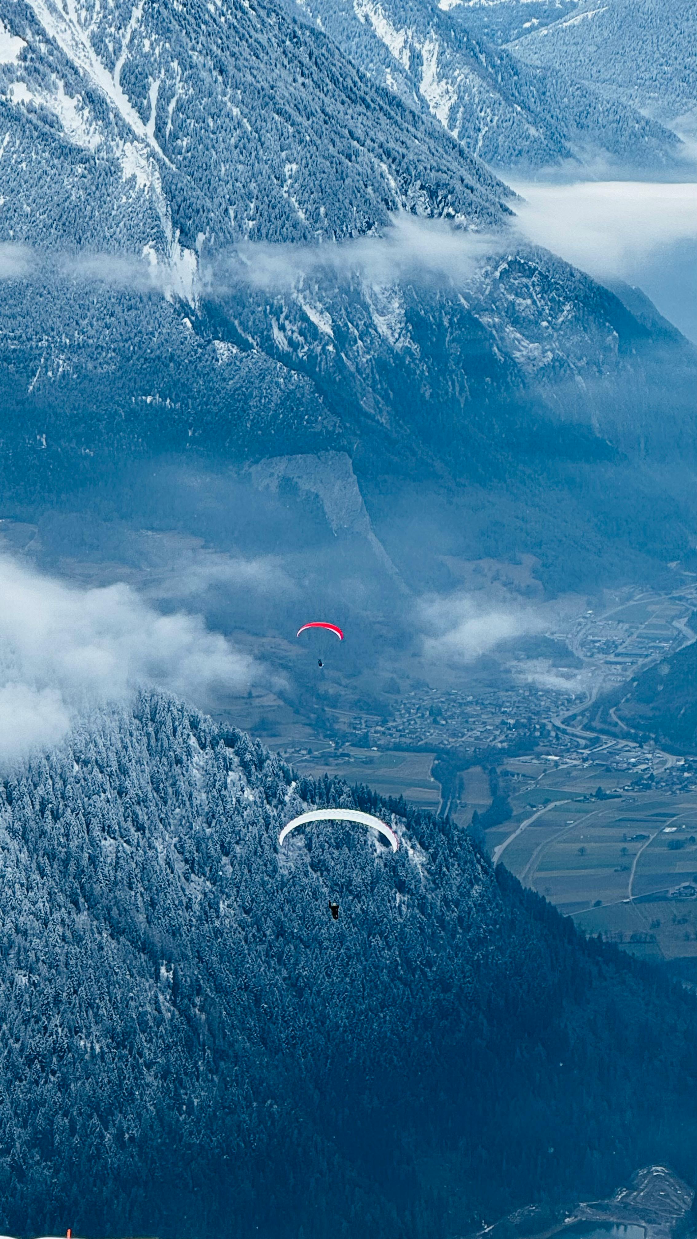 Two Parachutes Flying Over the Mountains in Snow · Free Stock Photo