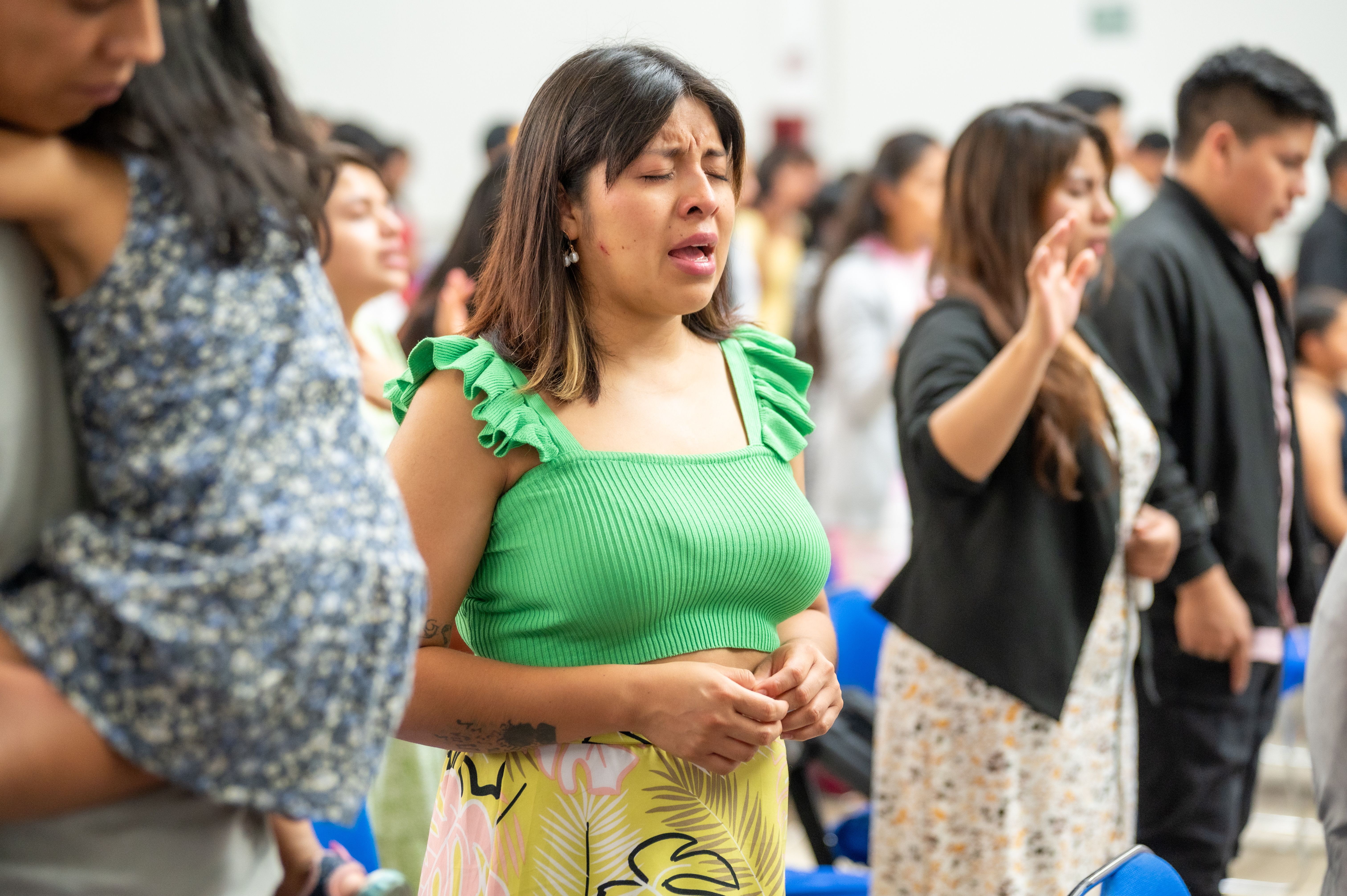 A woman in a green dress is praying · Free Stock Photo