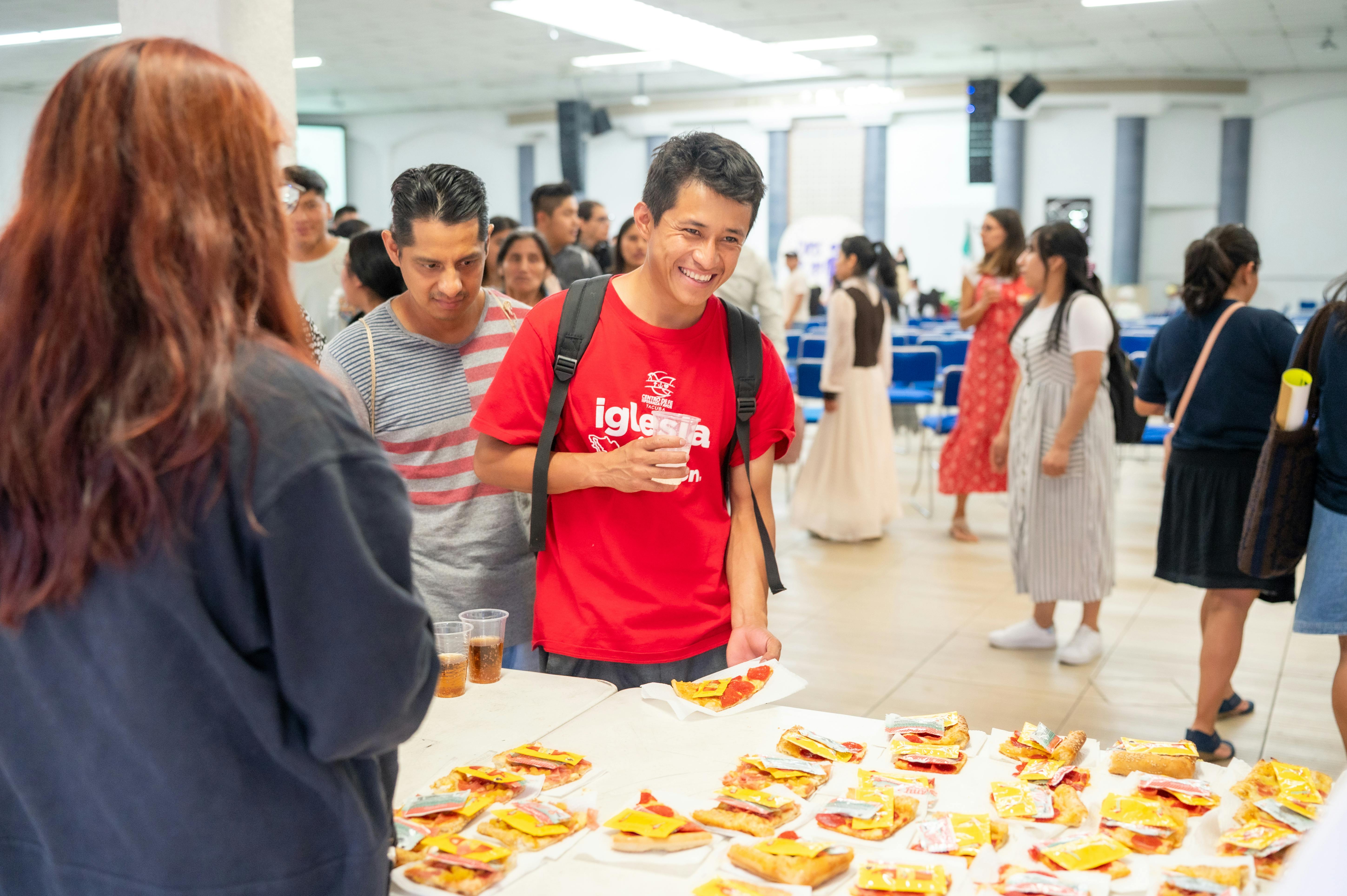 A group of people standing around a table with food · Free Stock Photo