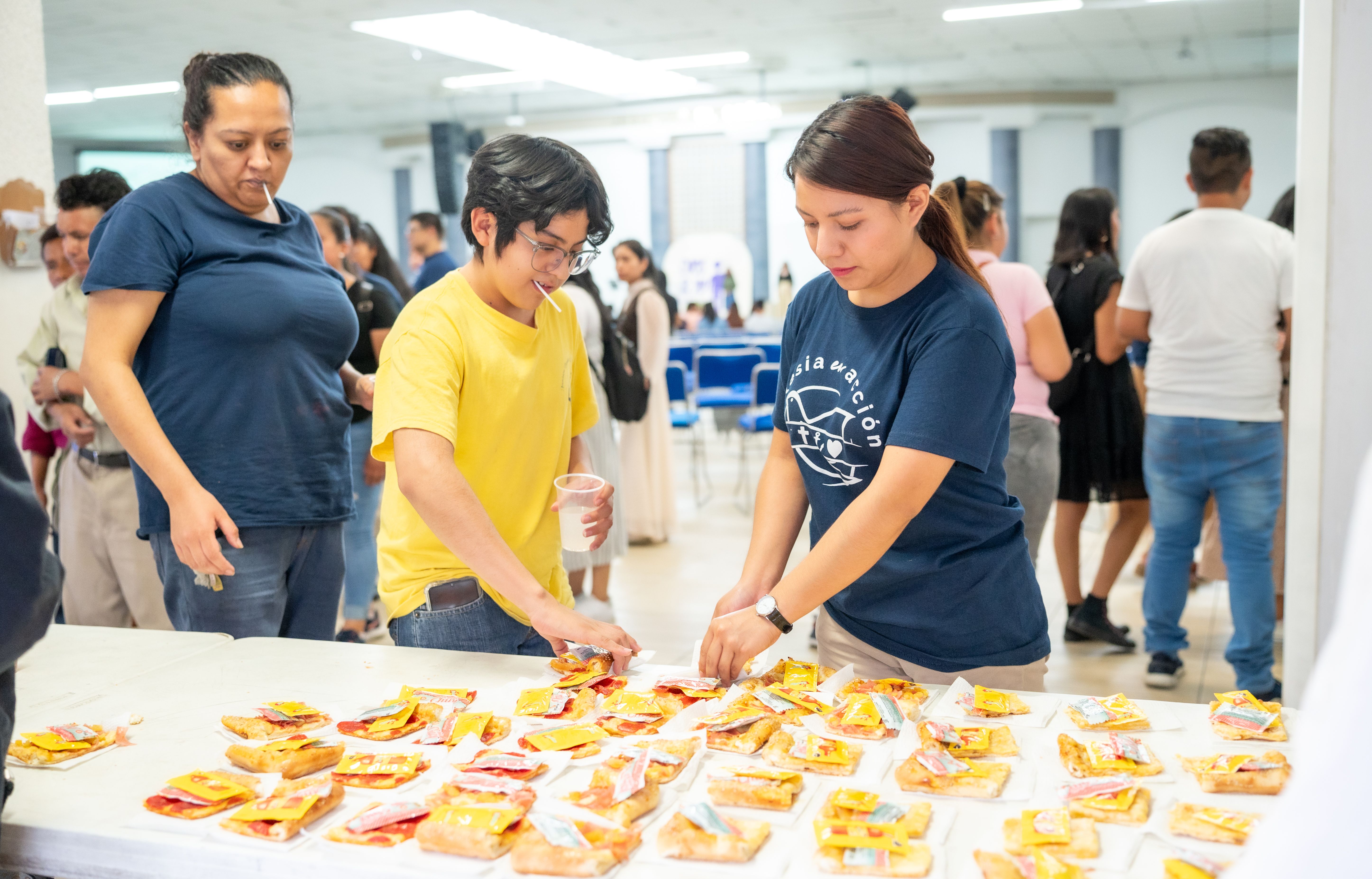 A group of people standing around a table with food · Free Stock Photo