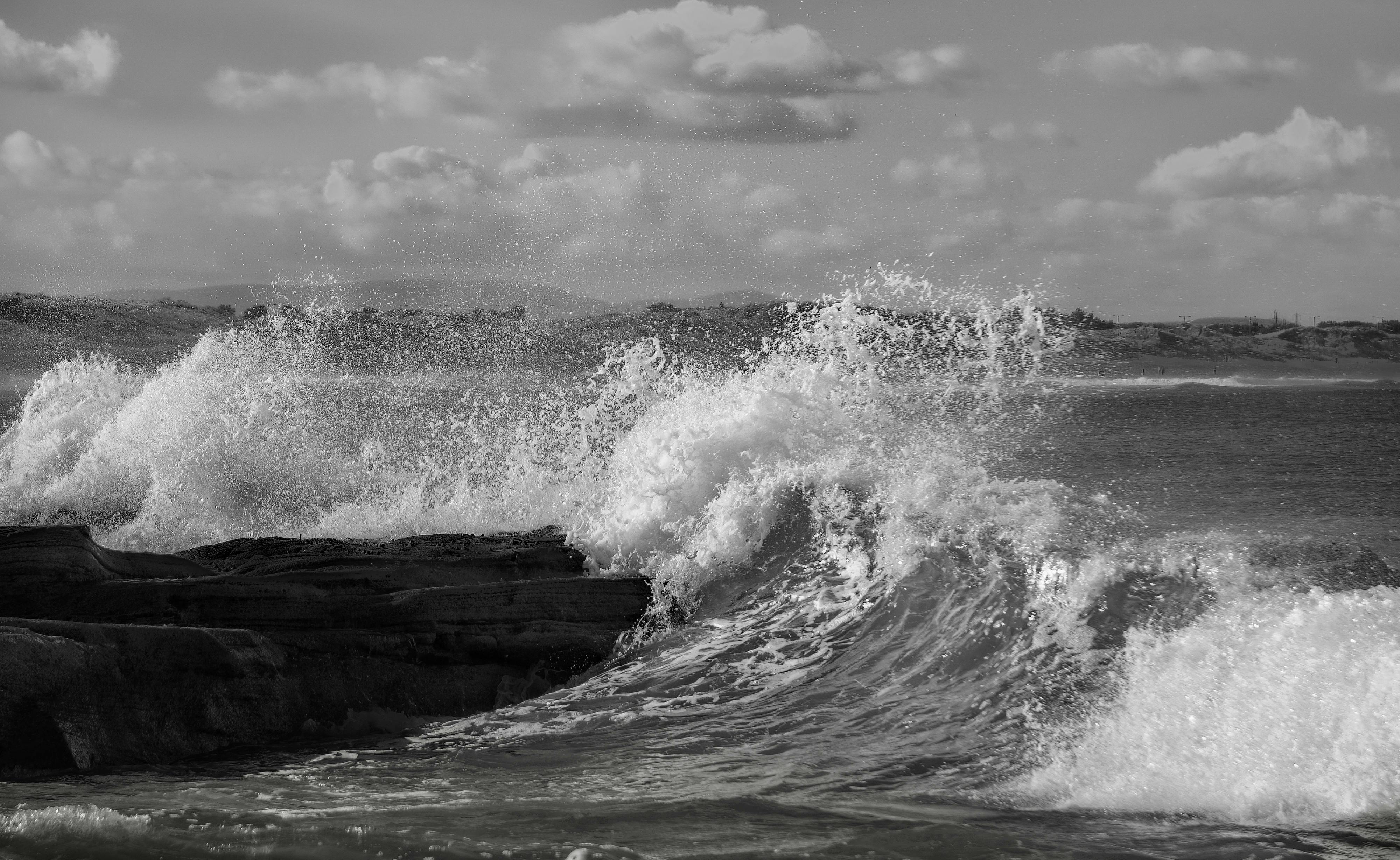 Black and white photo of waves crashing on rocks · Free Stock Photo