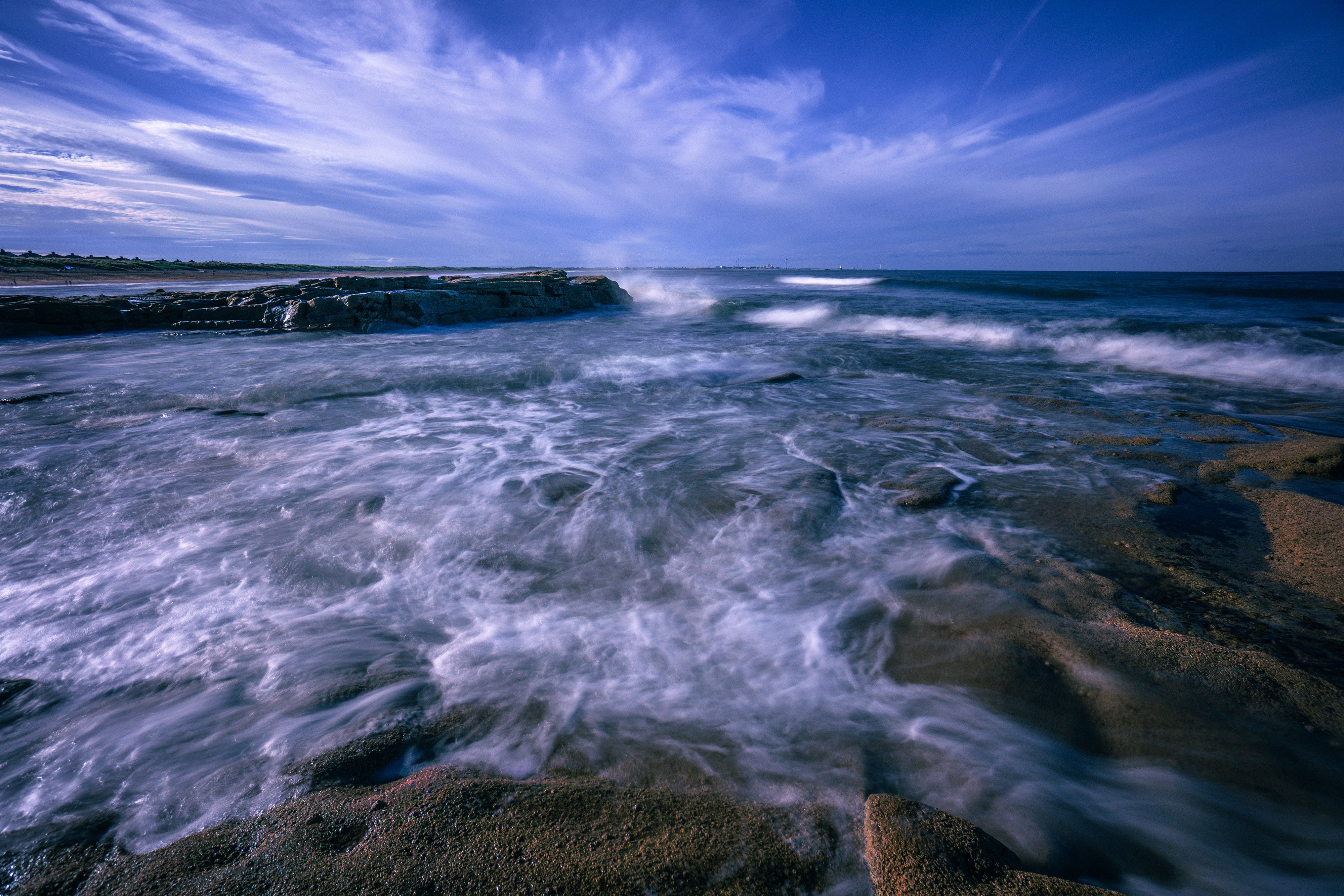 Long Exposure of Waves Breaking on a Rocky Shore · Free Stock Photo