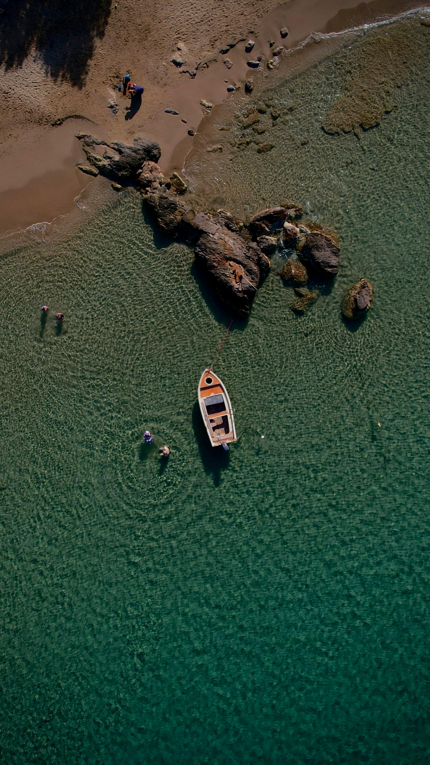 Aerial View of Tourists in the Sea and a Boat Moored by the Beach ...