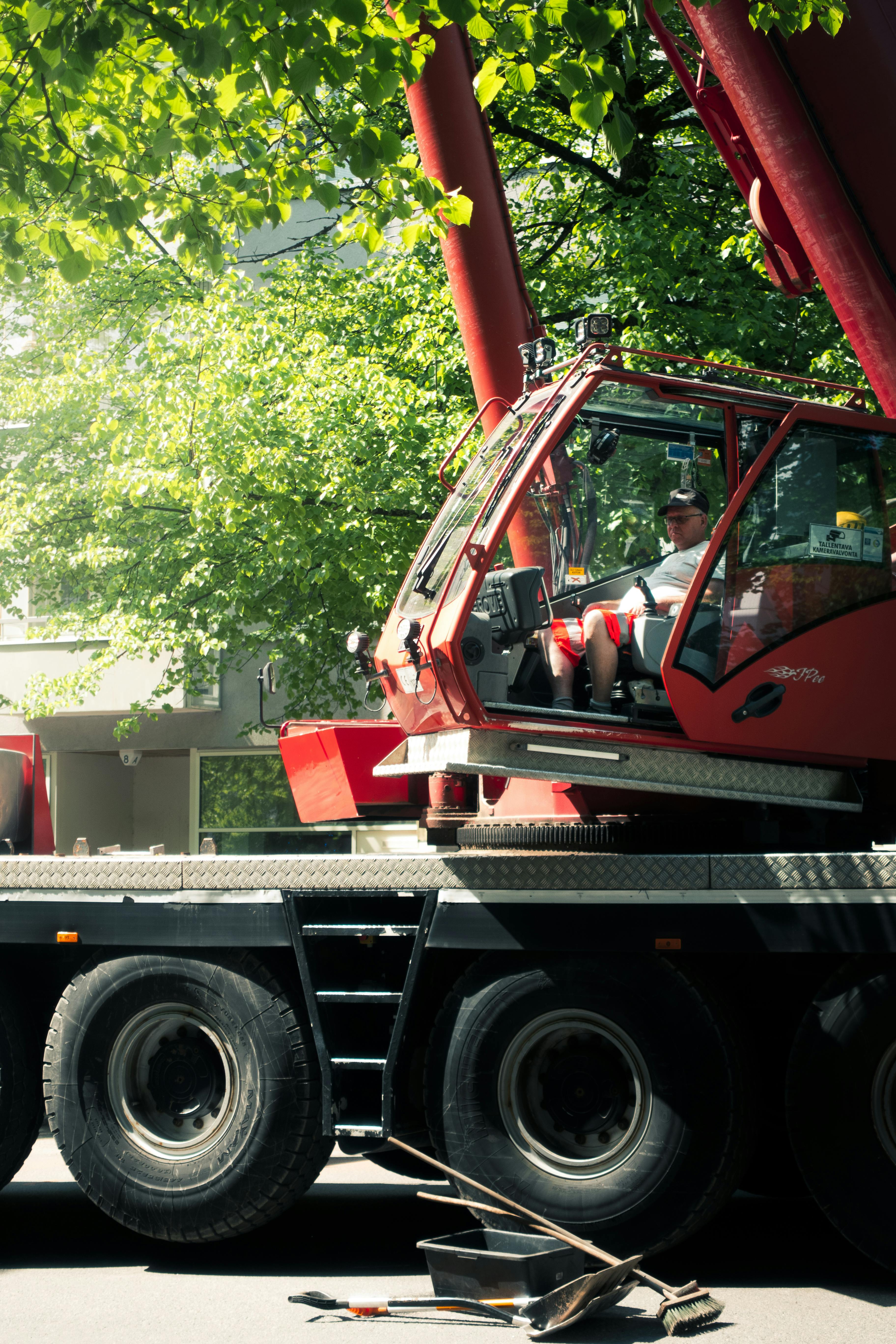 A Man Sitting Inside the Cabin of a Mobile Crane · Free Stock Photo