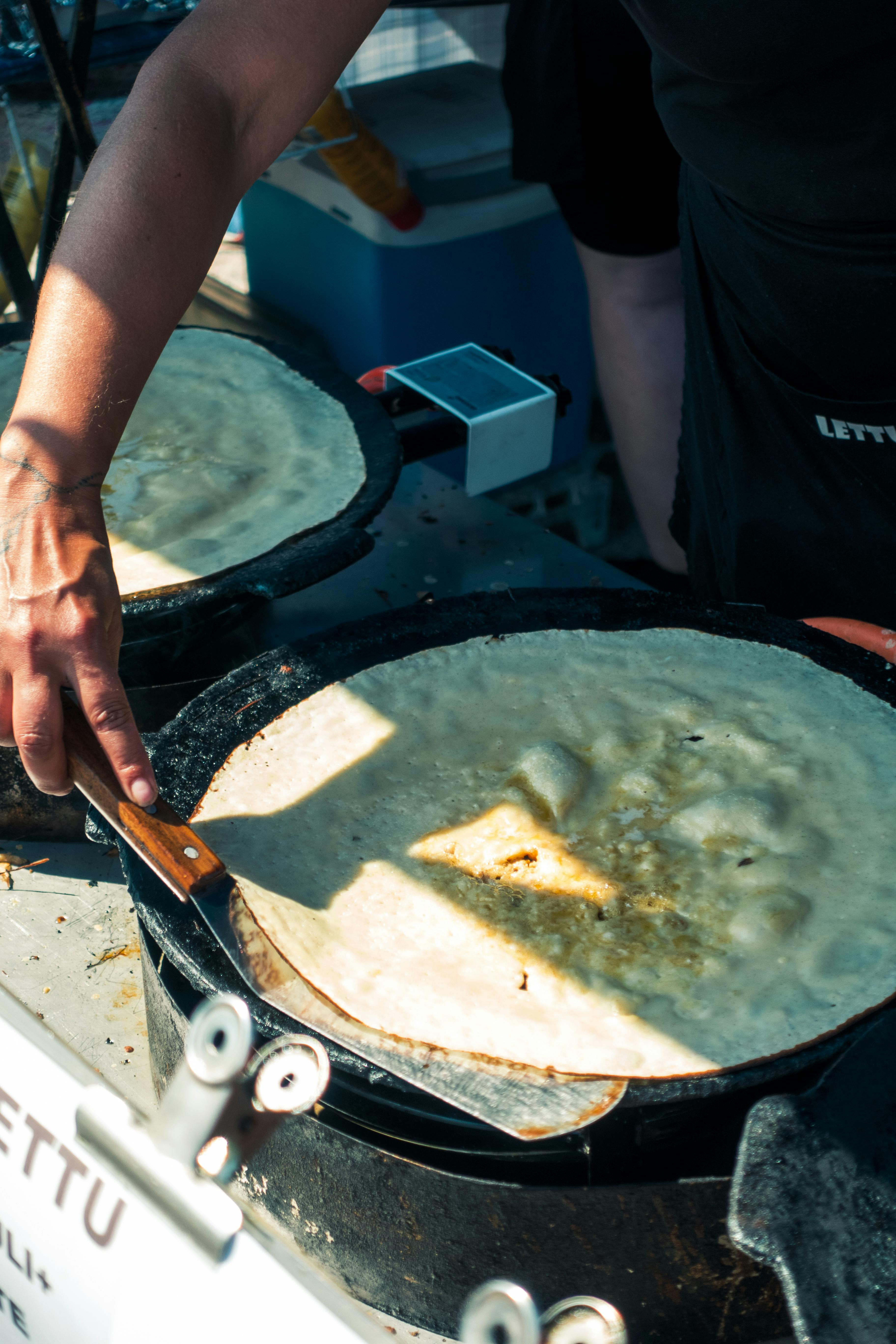 Man Cooking Pancakes on Stoves in Street Food Stand · Free Stock Photo