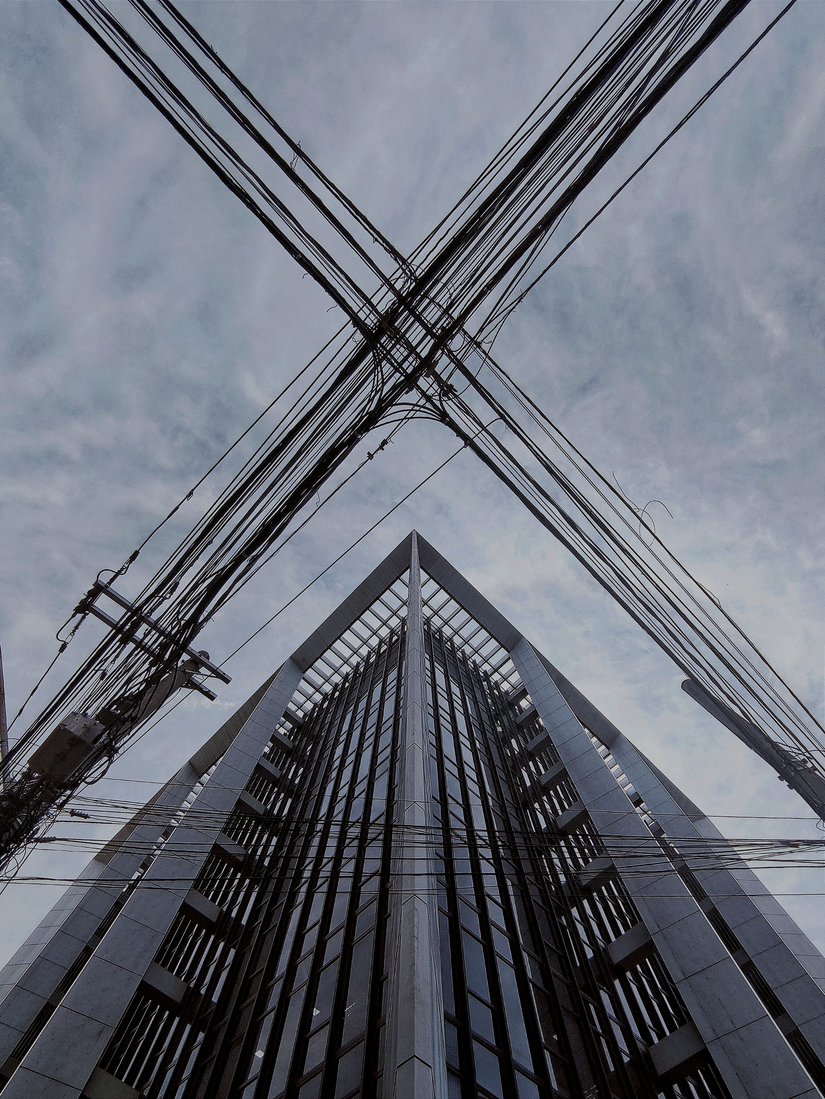 A tall building with wires and telephone poles · Free Stock Photo