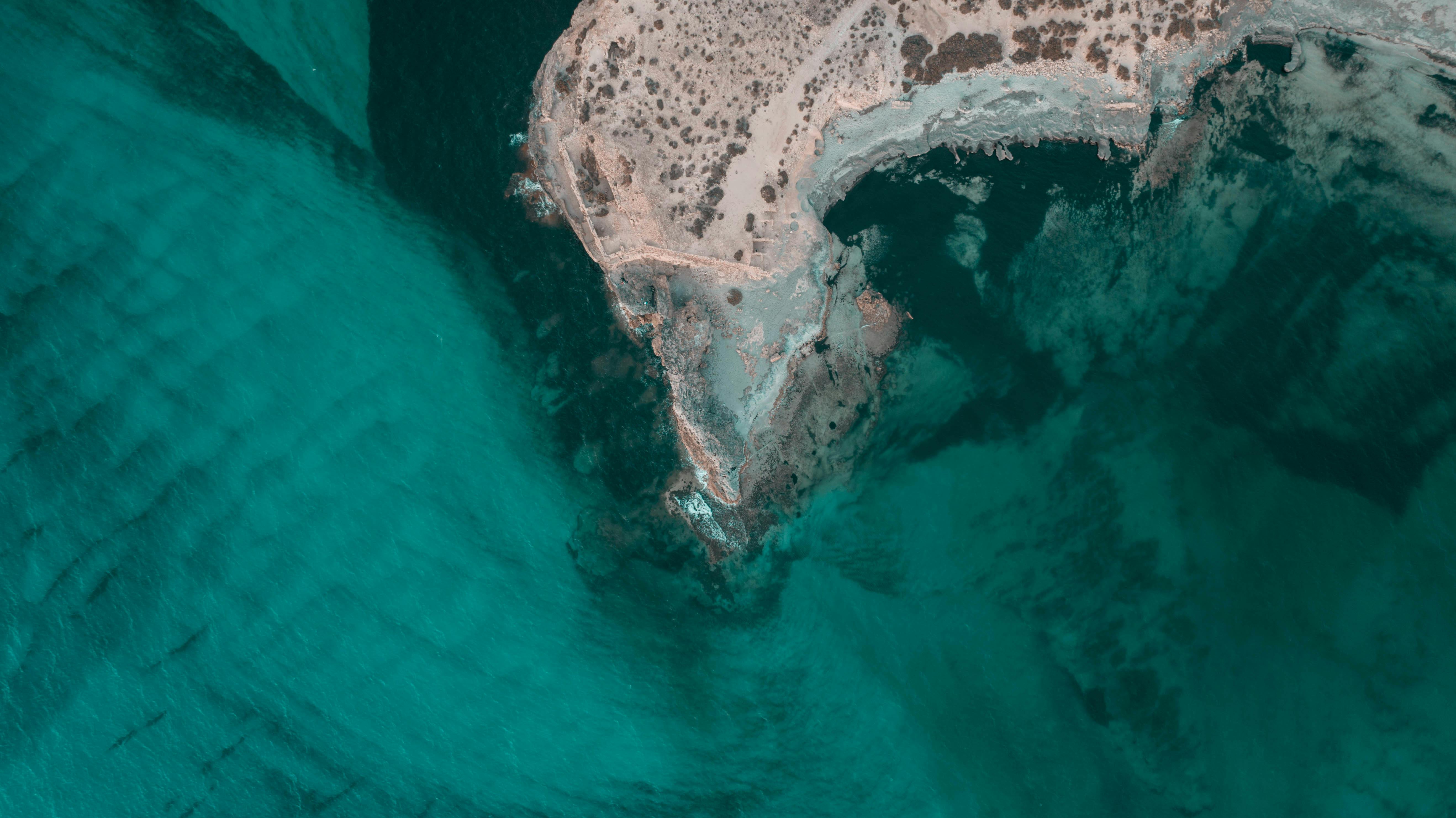 Aerial View of a Desert Peninsula on a Turquoise Sea · Free Stock Photo
