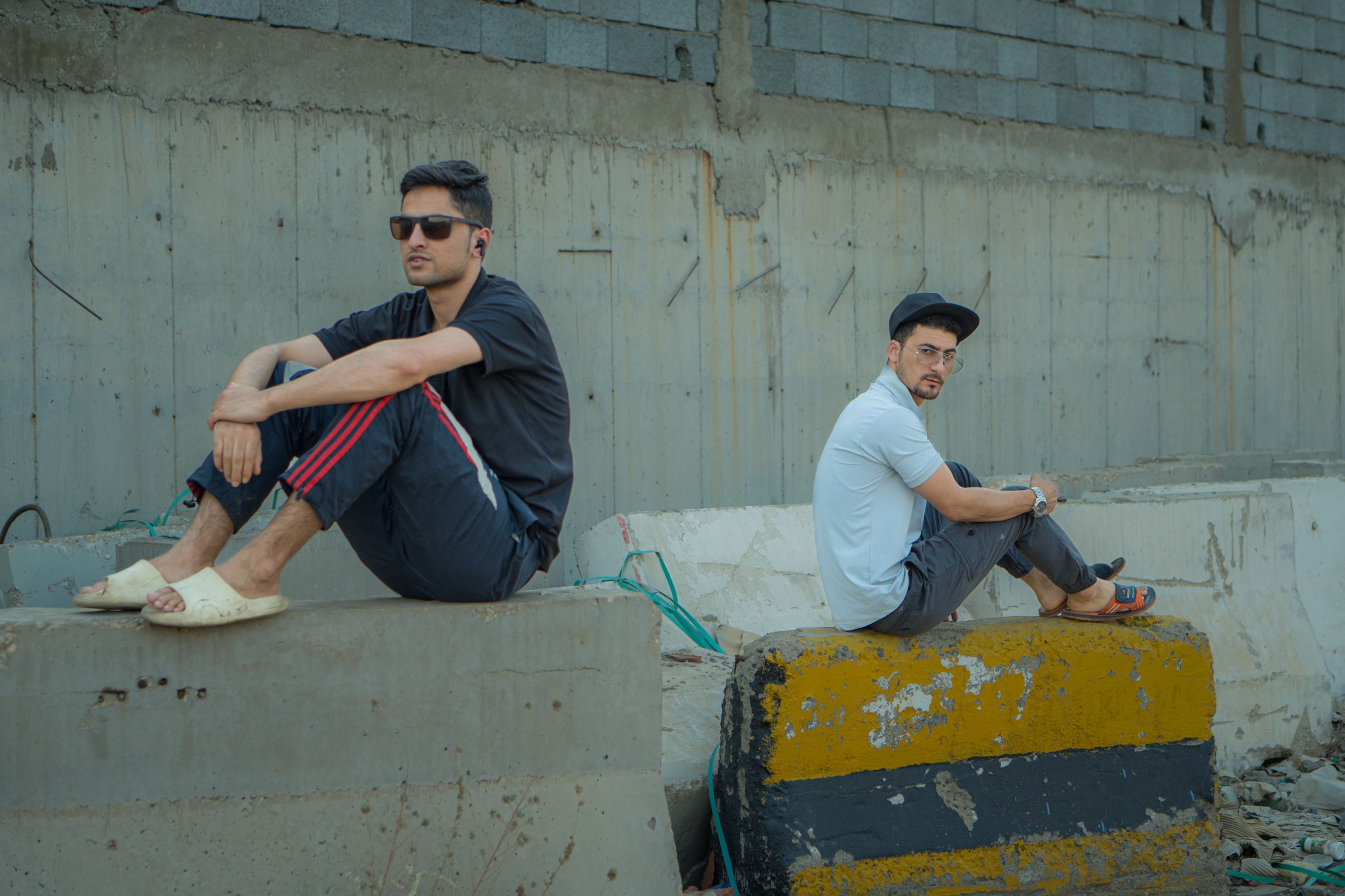 Men Posing Sitting on Traffic Construction Blocks · Free Stock Photo